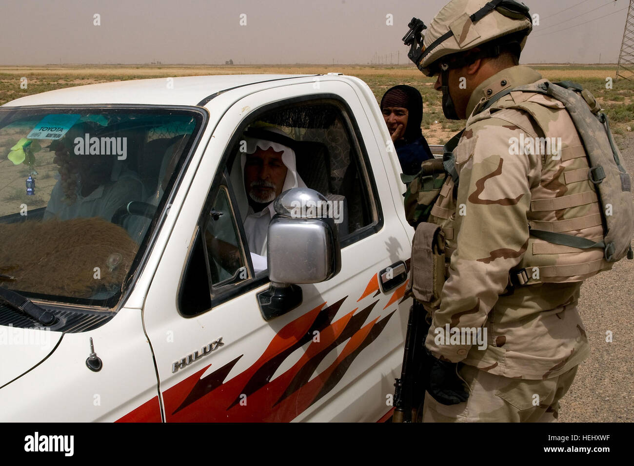 An Iraqi army soldier verifies an Iraqi driver's documentation during a ...