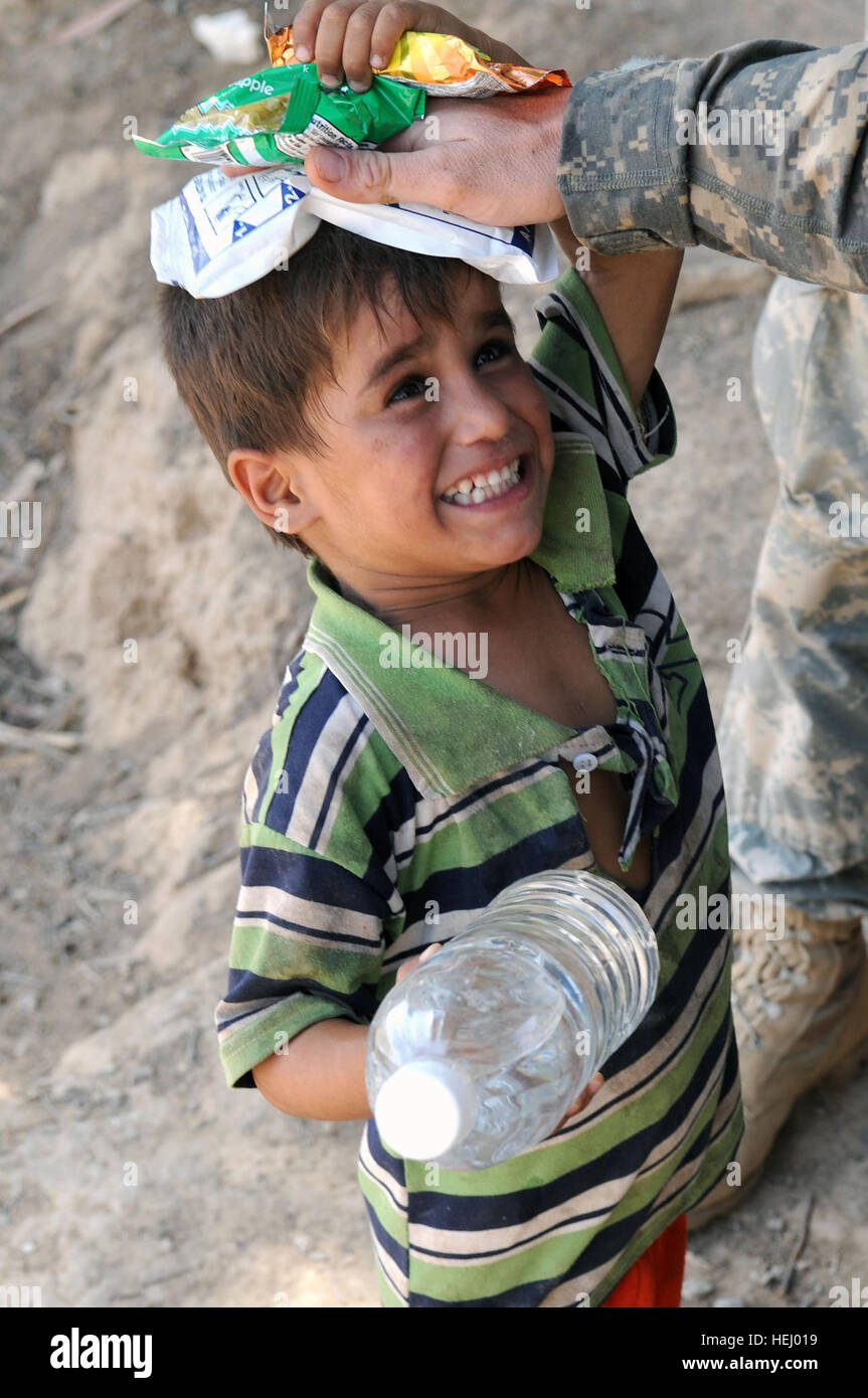 A young Iraqi boy holds snacks and water given to him by Iraqi and U.S ...