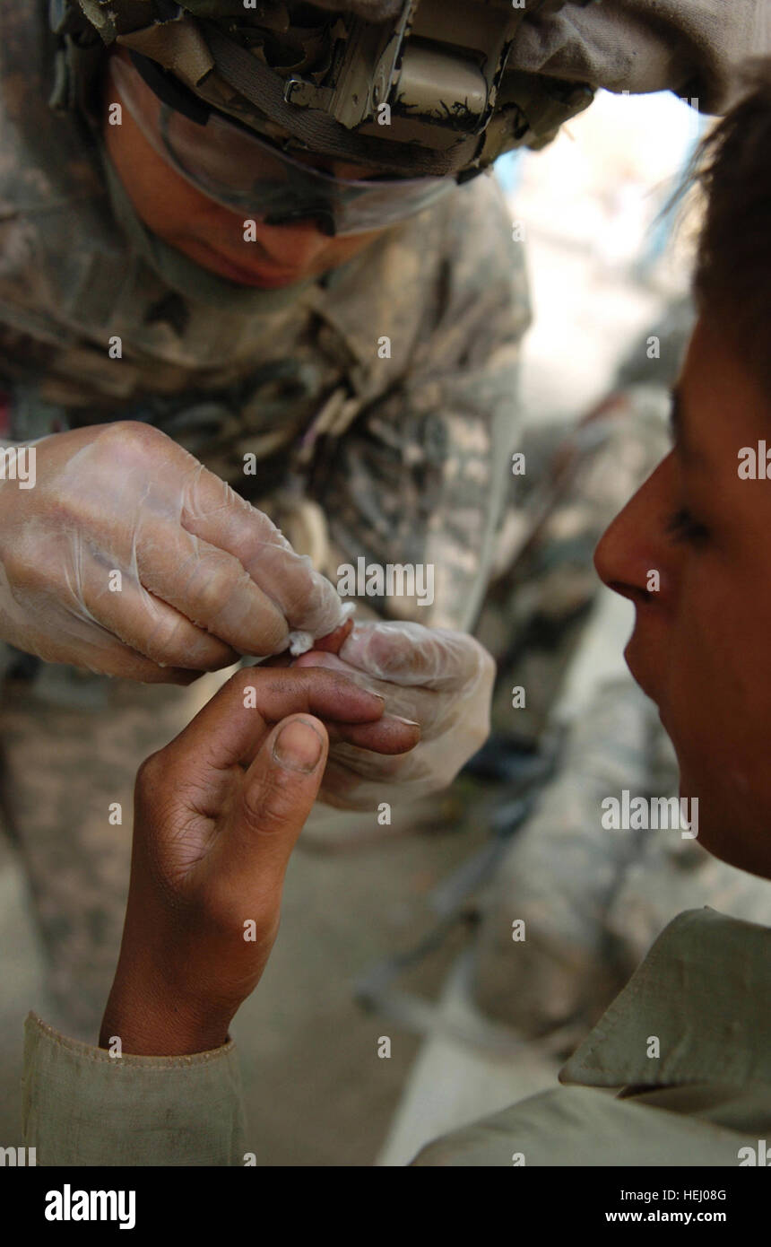 U.S. Army Sgt. Arturo Islas bandages an Afghan boy's injured finger ...