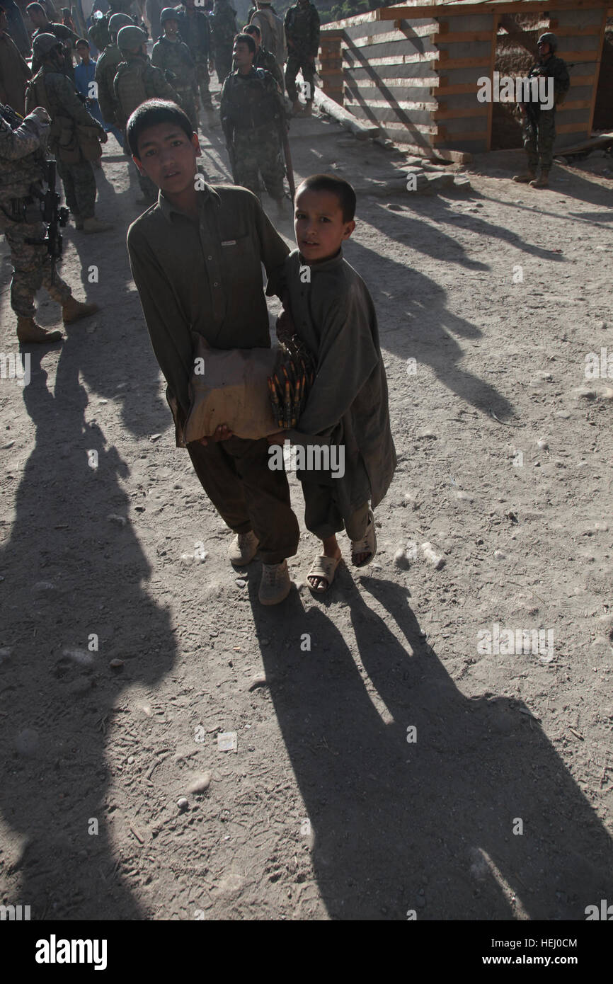 Two Afghan children turn over ammunition left behind by the Taliban in ...