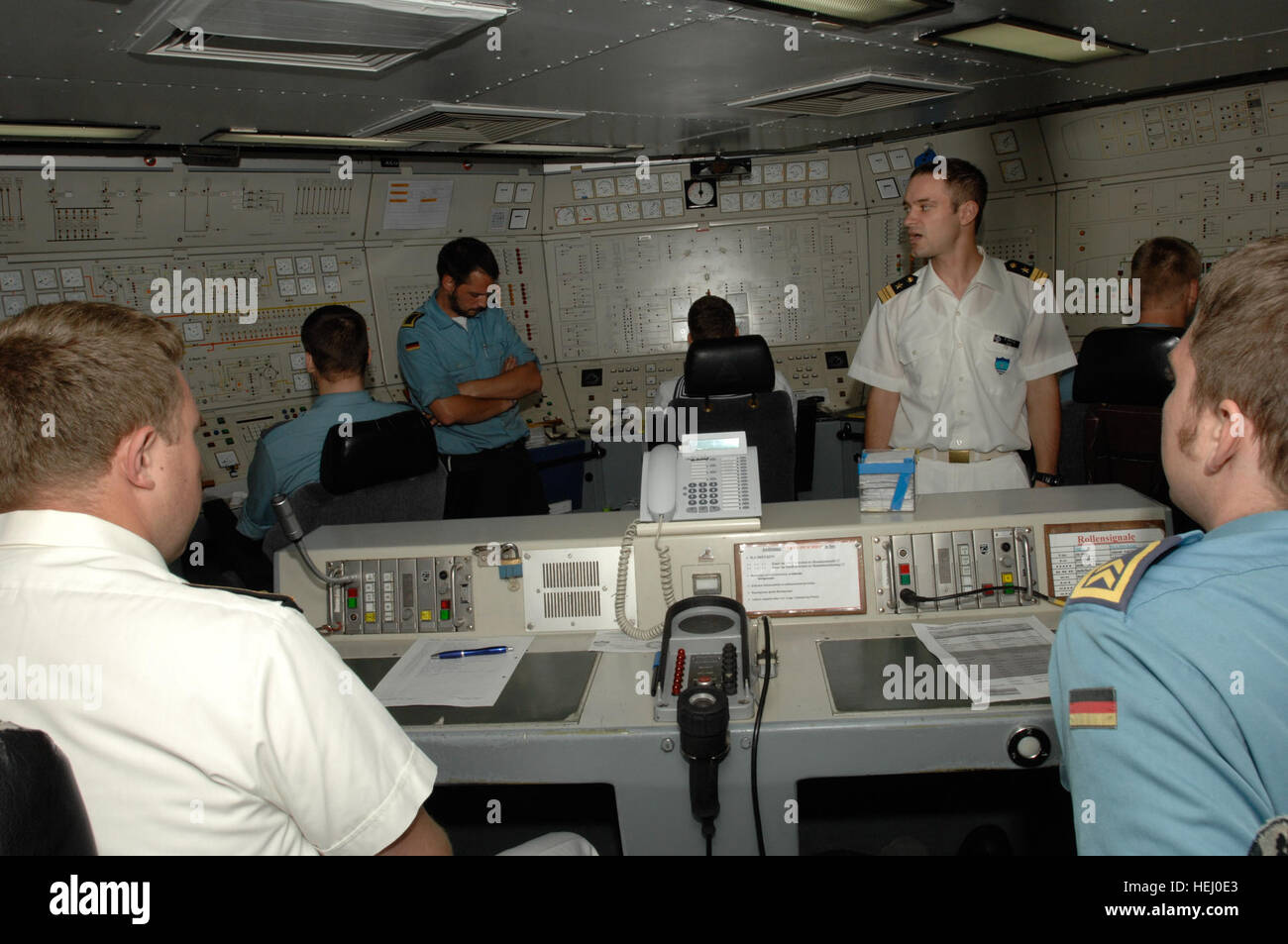 Crew members of the German frigate Emden operate stations and provide ...