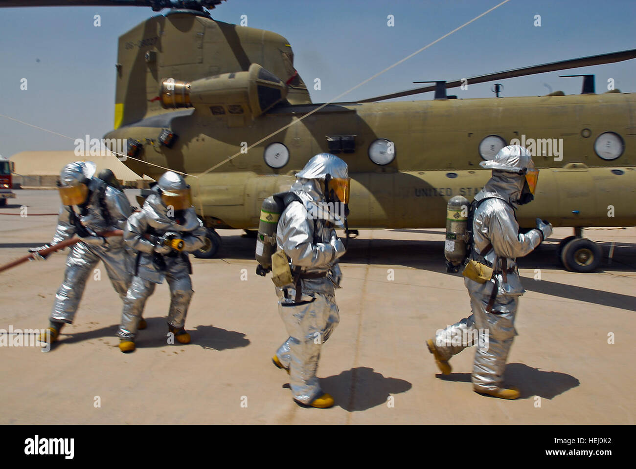 Fully suited firefighters from the Taji fire department move quickly to ...