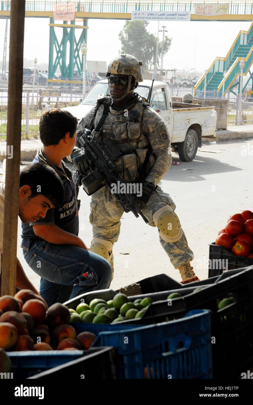 A man picks out fruit and a boy looks at Staff Sgt. Omar Jackson, an ...