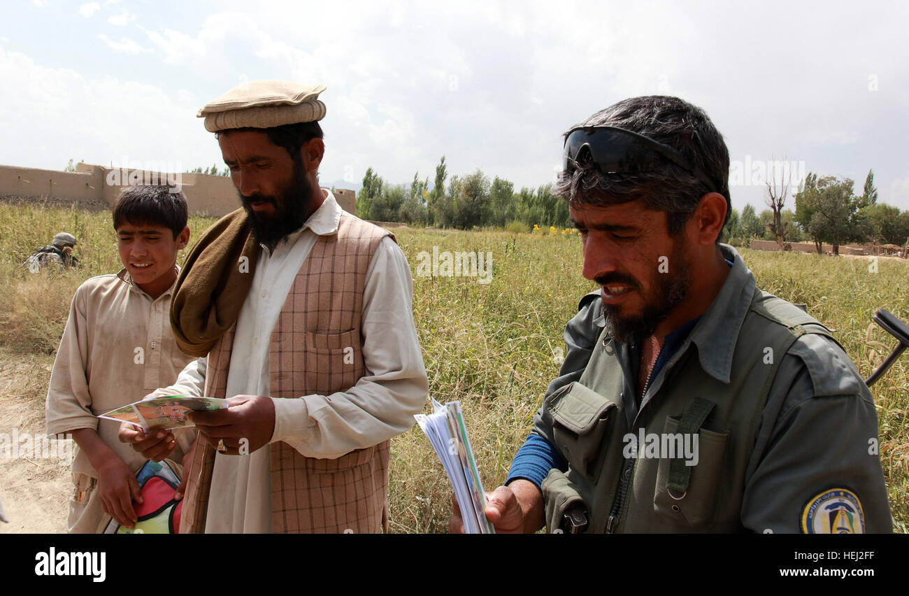 An Afghan local looks at a flier, which has a tip line phone number to ...