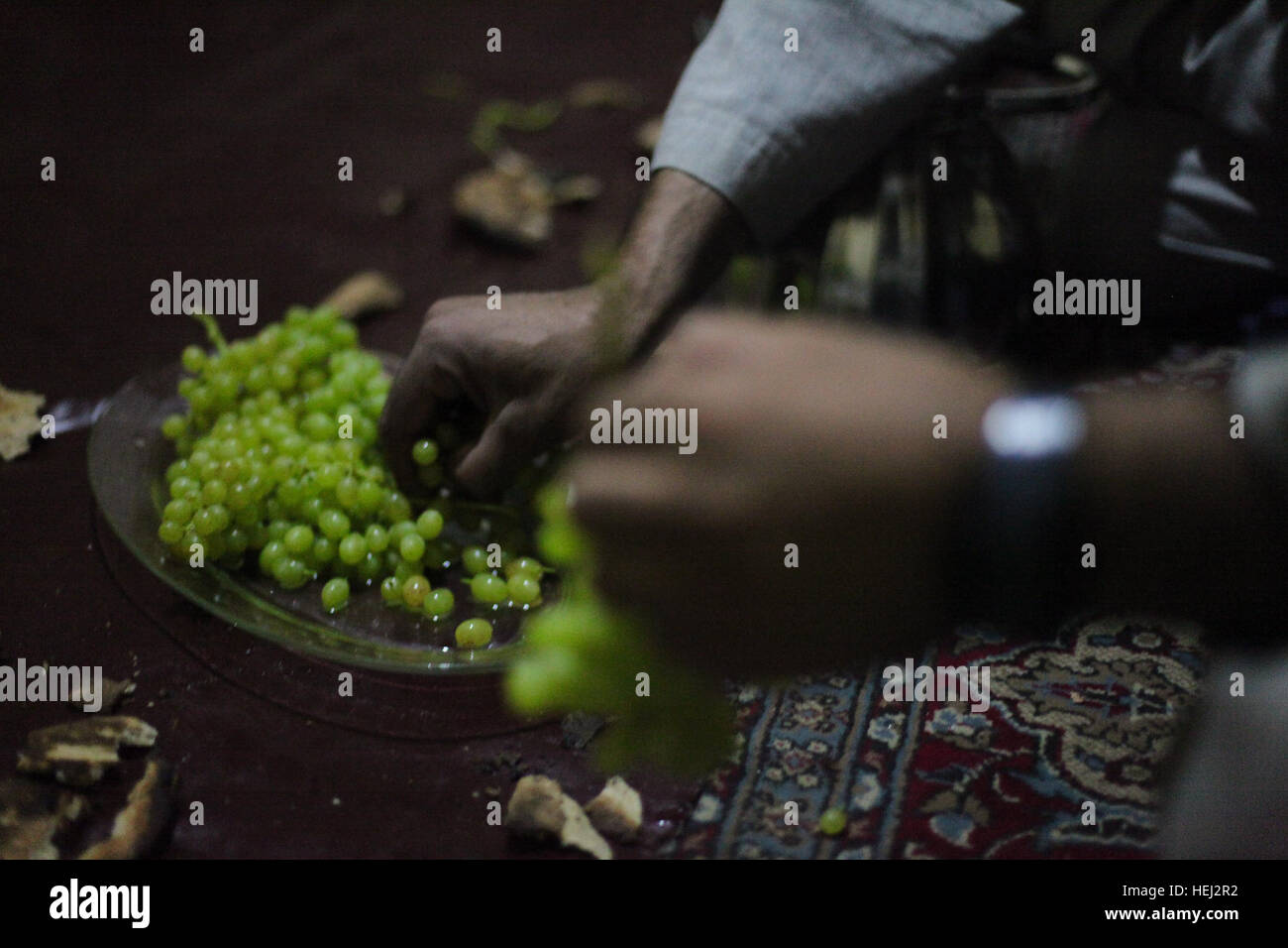 Local Afghan national police officers eat fresh grapes at a dinner ...