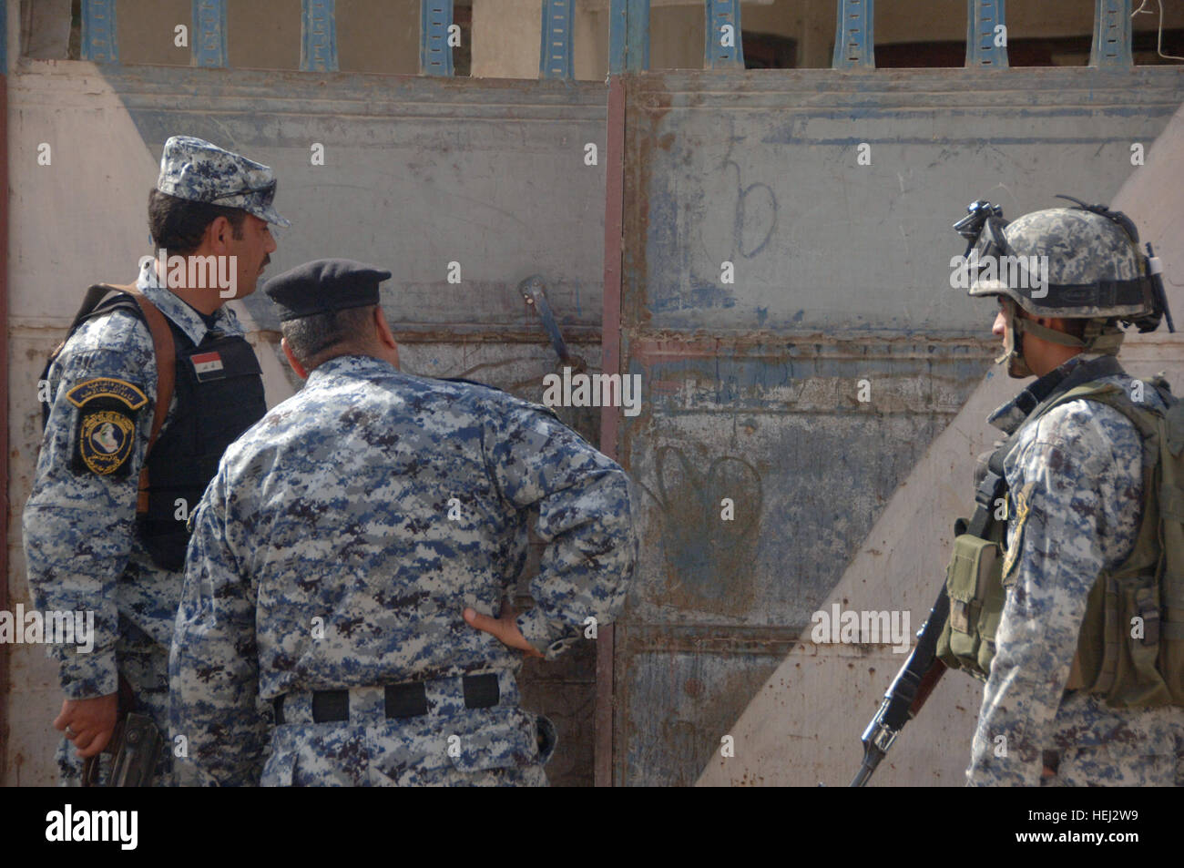 Members of the Iraqi national police command observe a building while ...