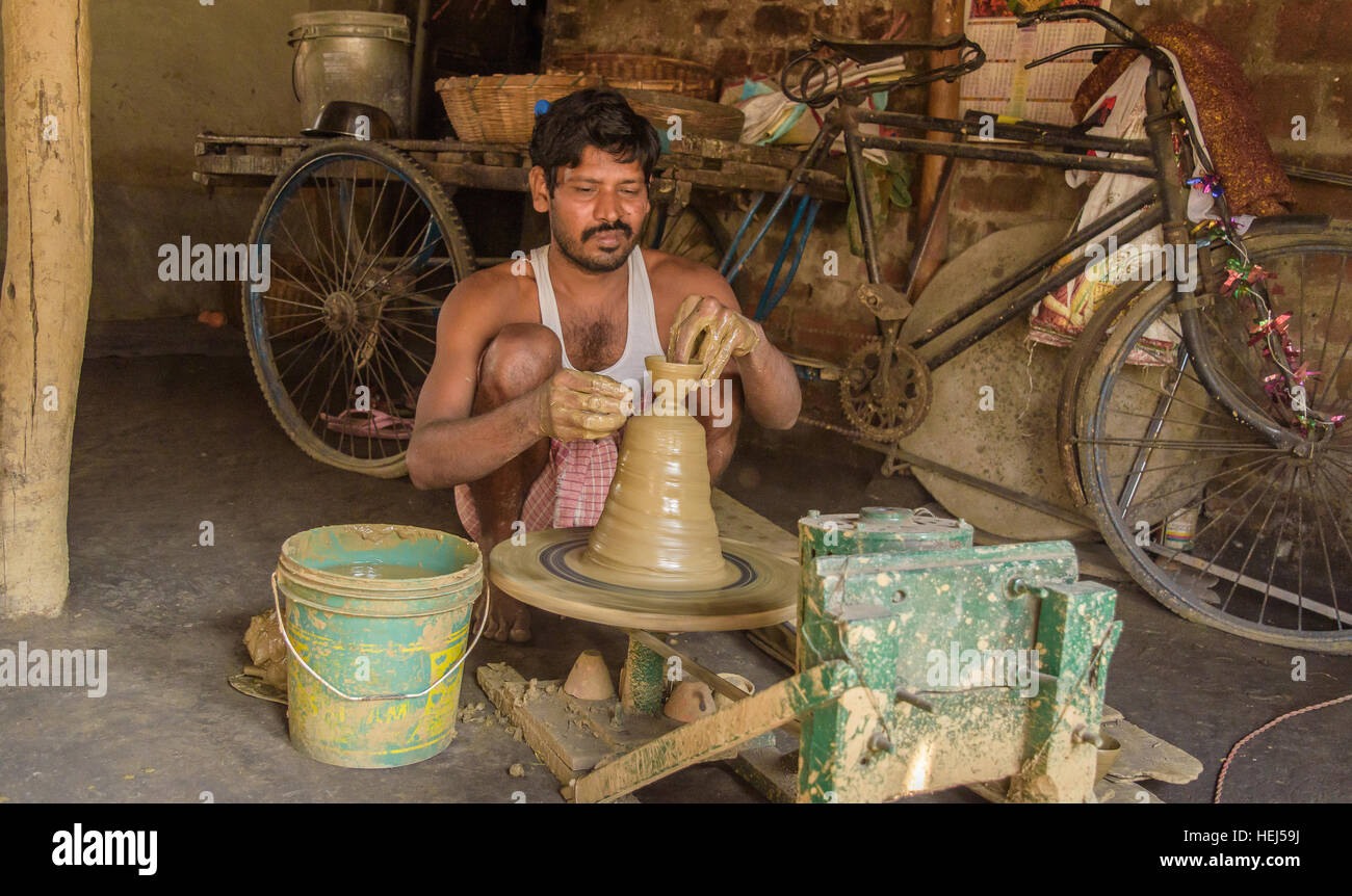 A village potter is making tea pots at his home in Durgapur, West ...