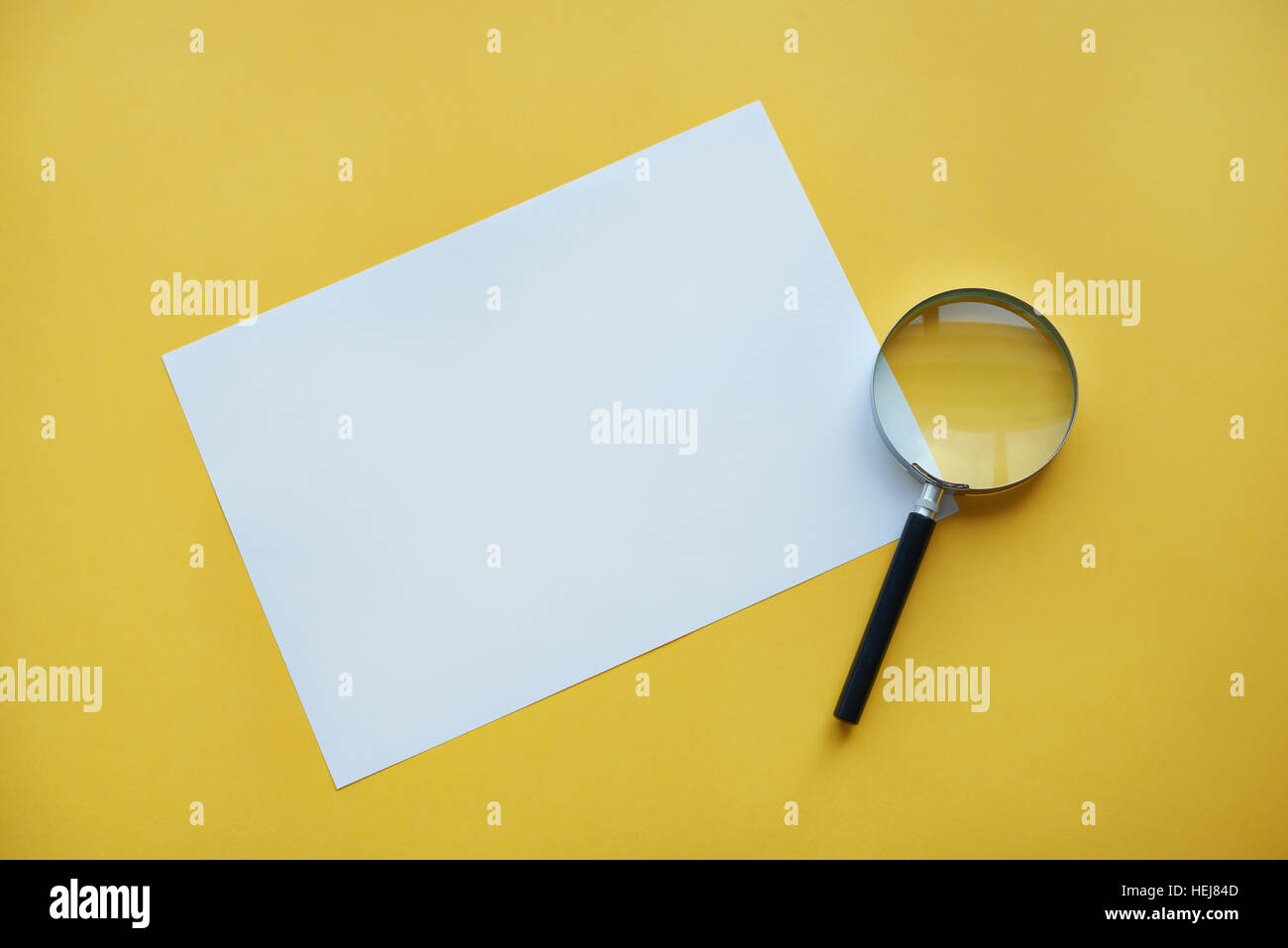 Magnifying glass and piece of paper Stock Photo - Alamy