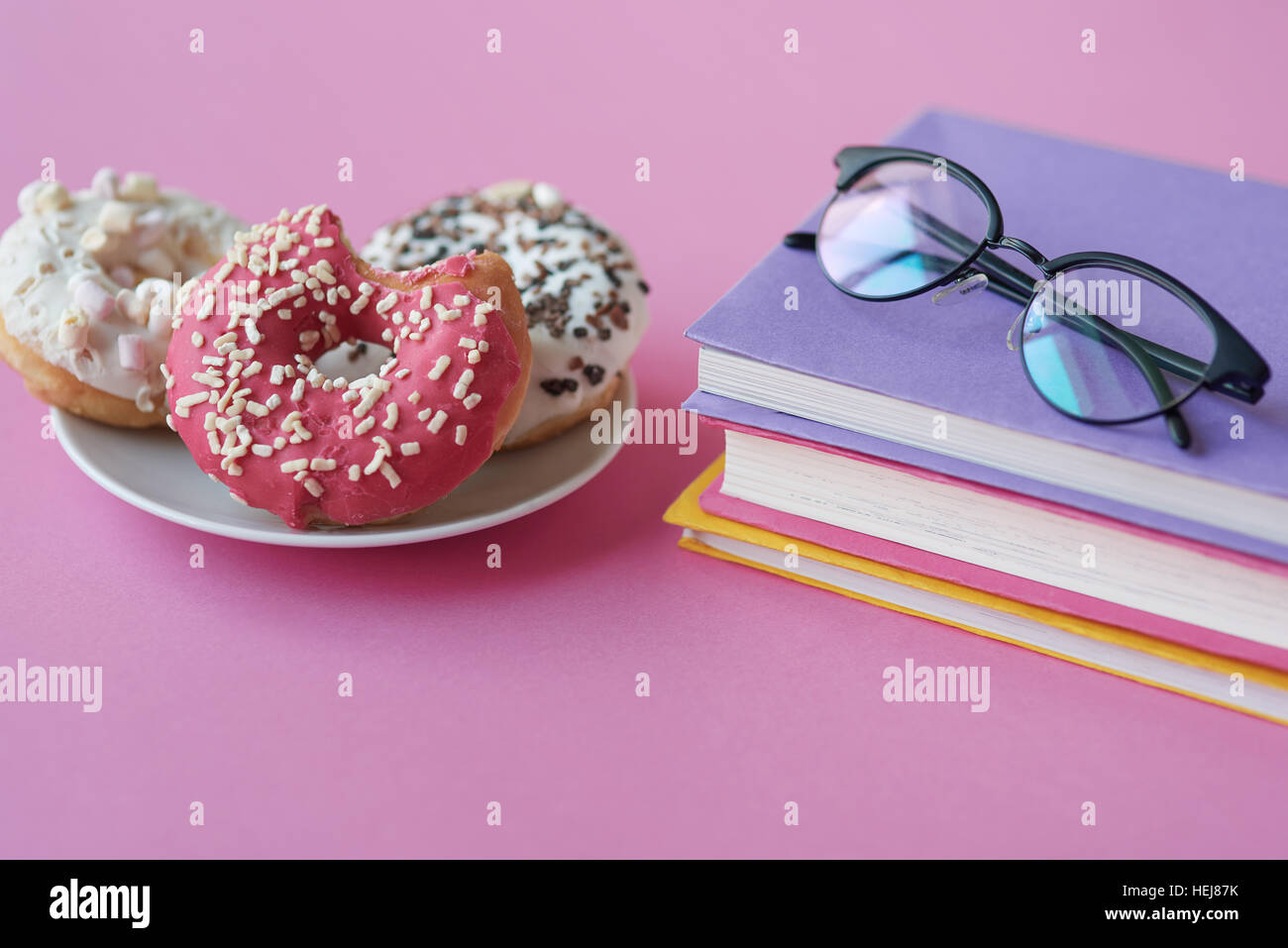 Glazed donuts placed next to eyeglasses and notebook Stock Photo - Alamy