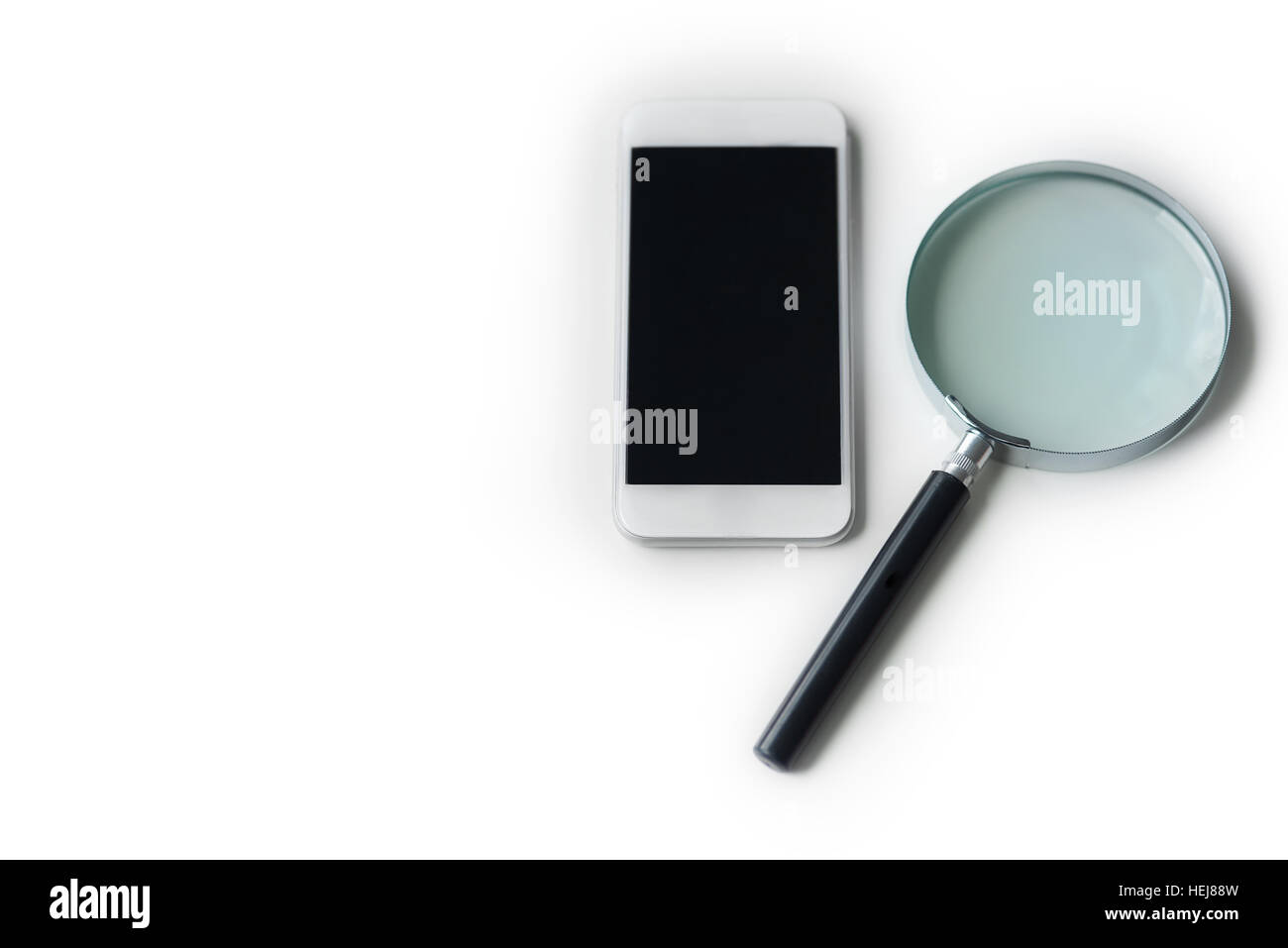 Cell phone next to magnifying glass Stock Photo - Alamy