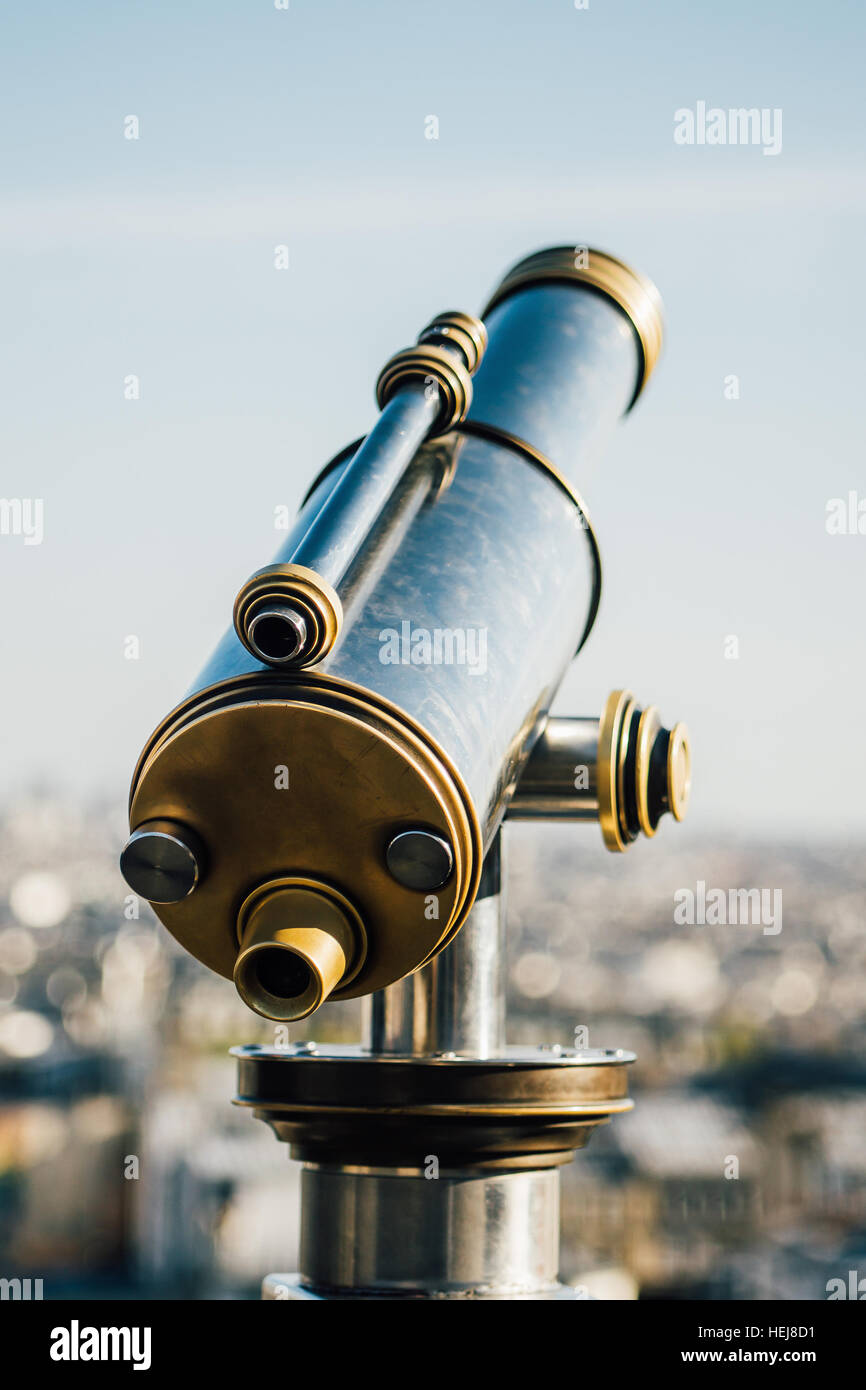A closeup of a silver and gold telescope to observe the city Paris ...