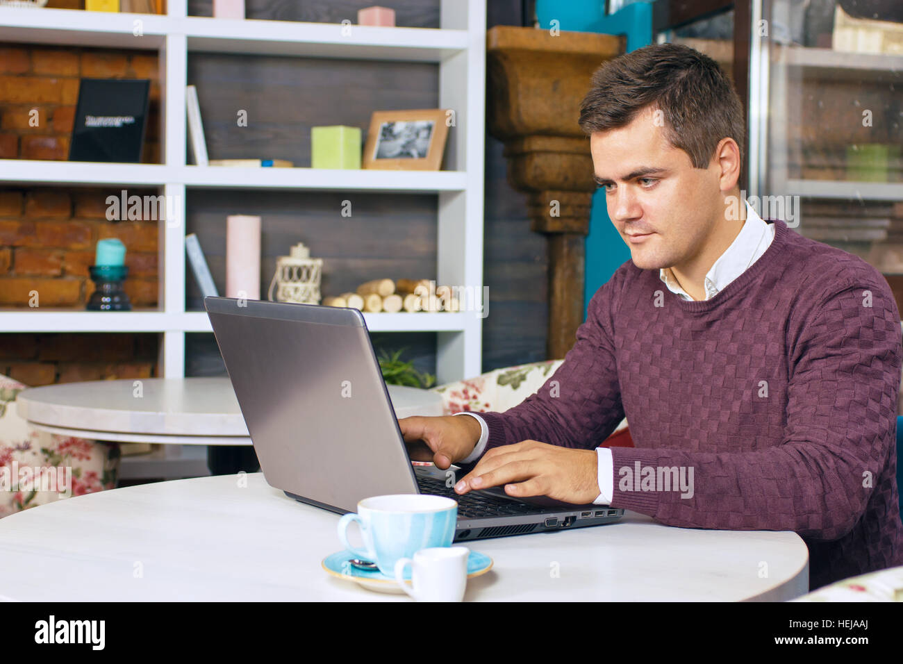 Happy young man smiling and works on his laptop Stock Photo - Alamy