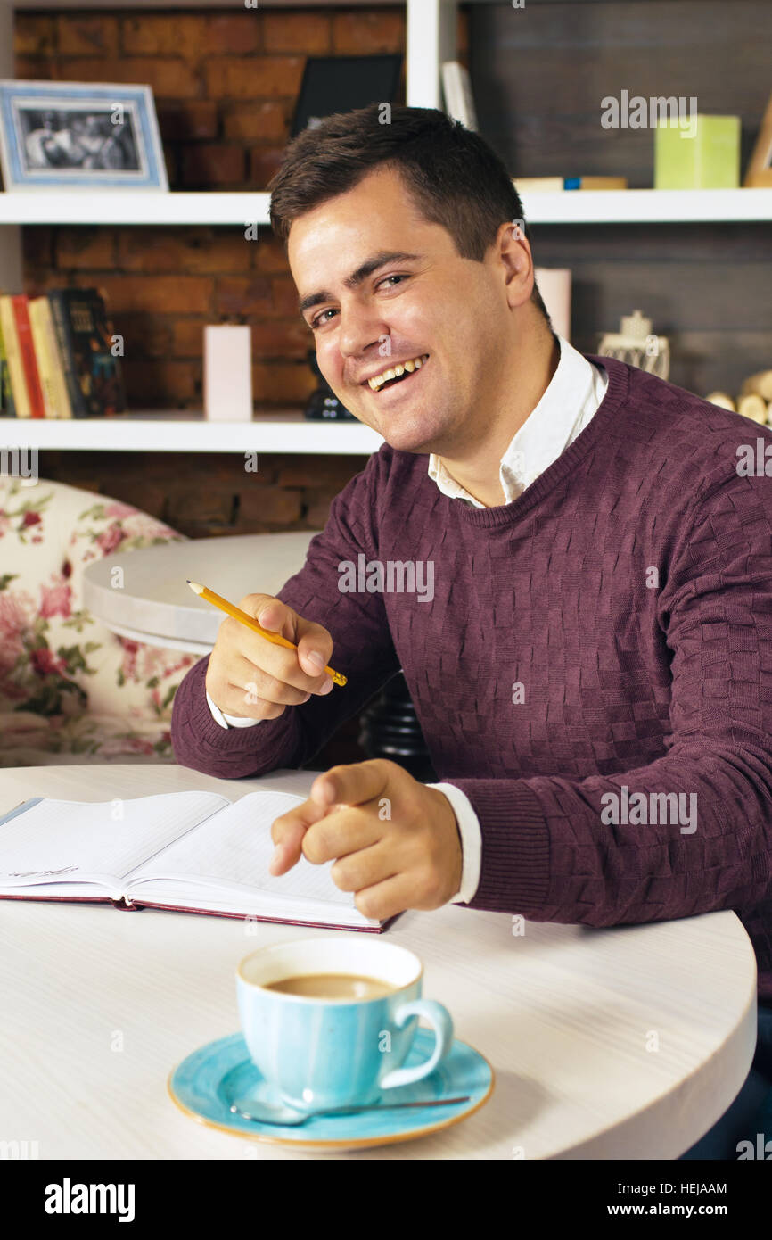 Man holding pencil and writing on a paper in the diary Stock Photo - Alamy