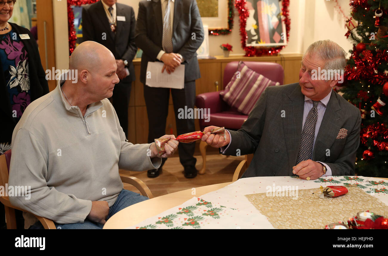 The Prince of Wales pulls a Christmas cracker with Andrew Kemp during a ...
