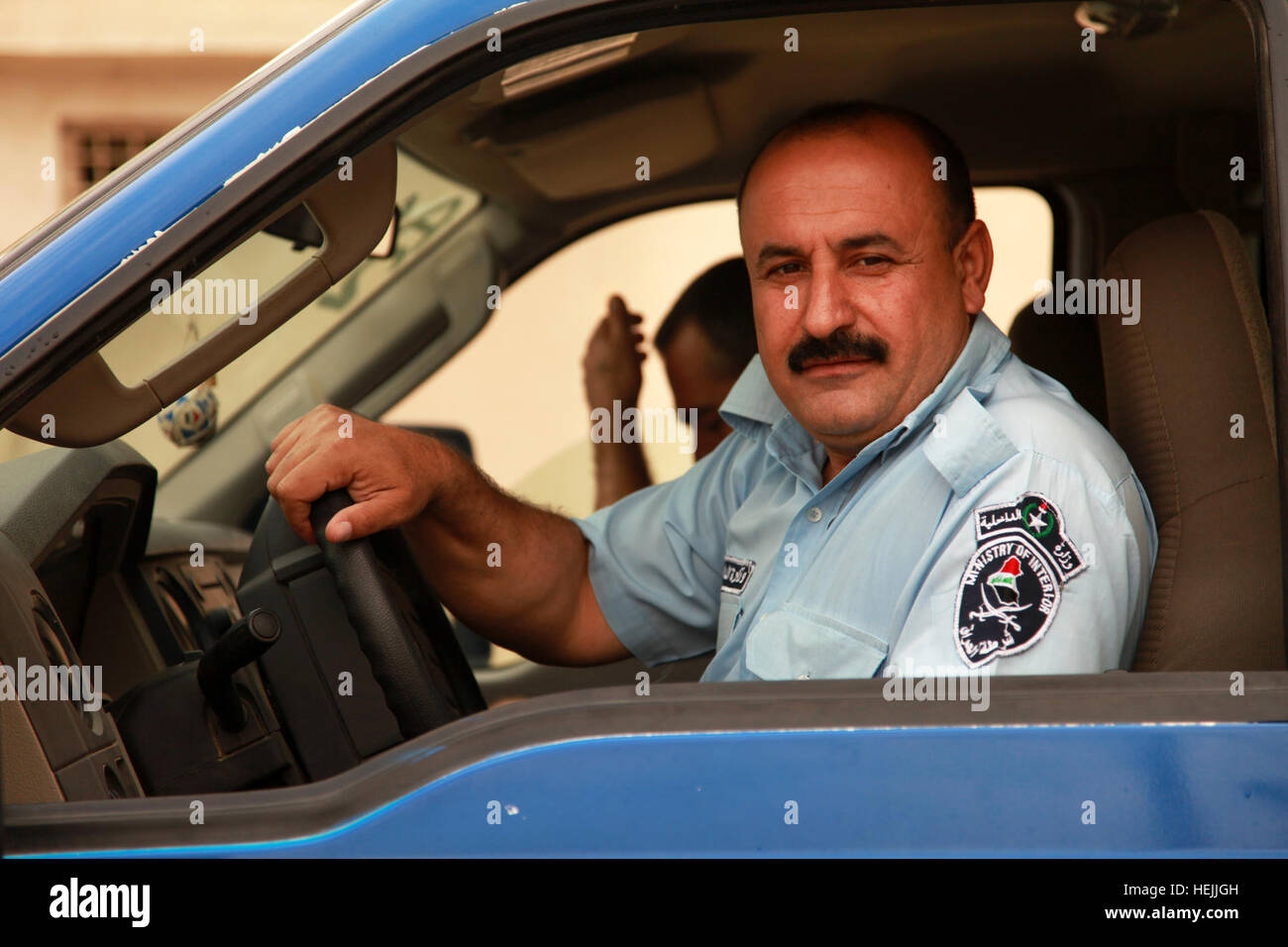 An Iraqi police officer glances at the camera during a humanitarian-aid ...