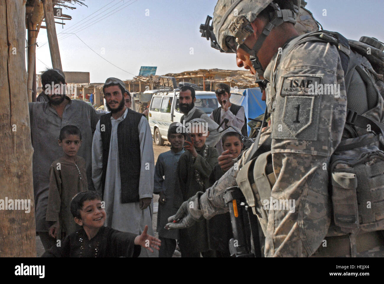 Sgt. Raymond Diaz, a 2-2 Inf. Soldier gives an Afghan boy a pen, a ...