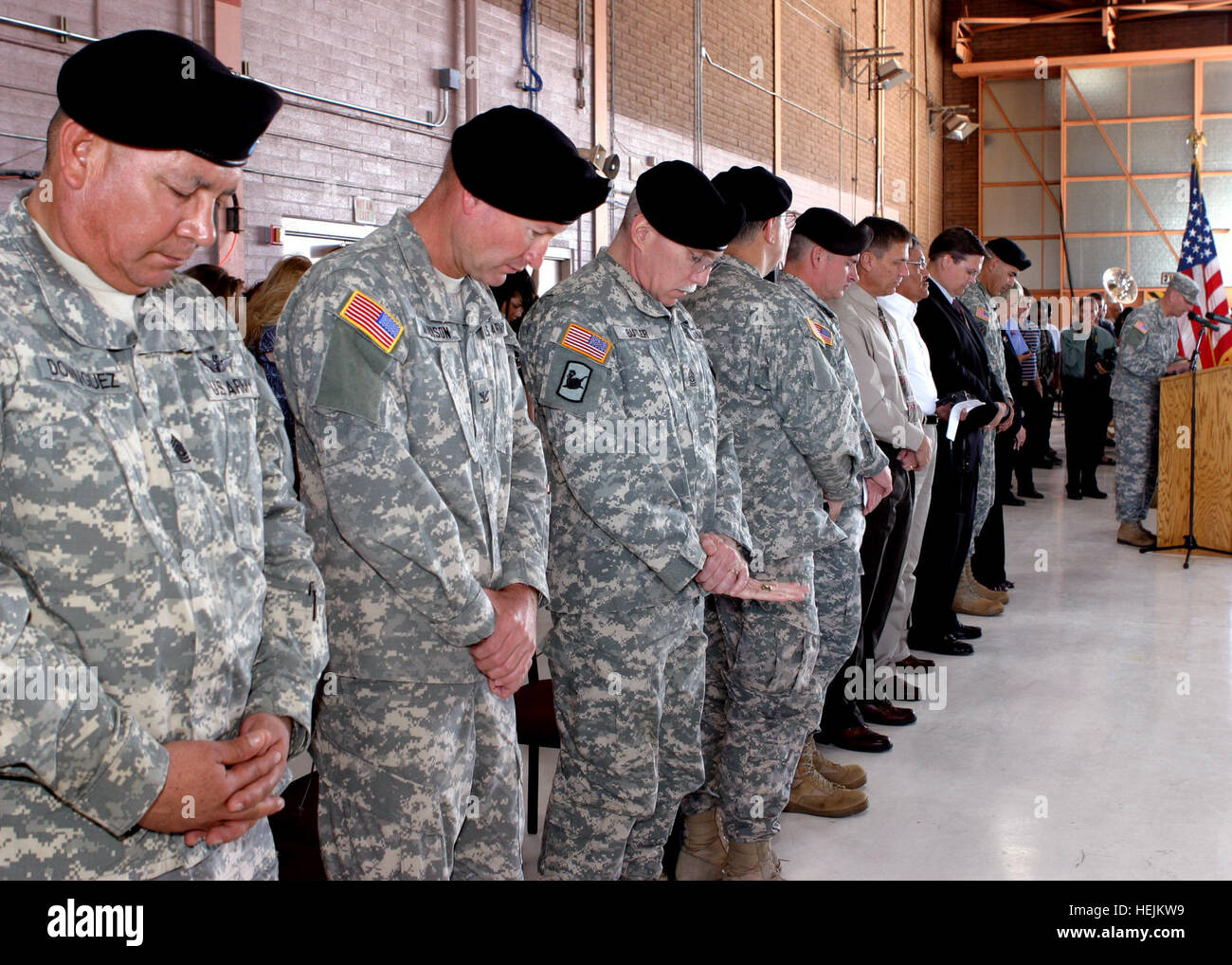 Members of the official party bow their heads for the invocation during ...