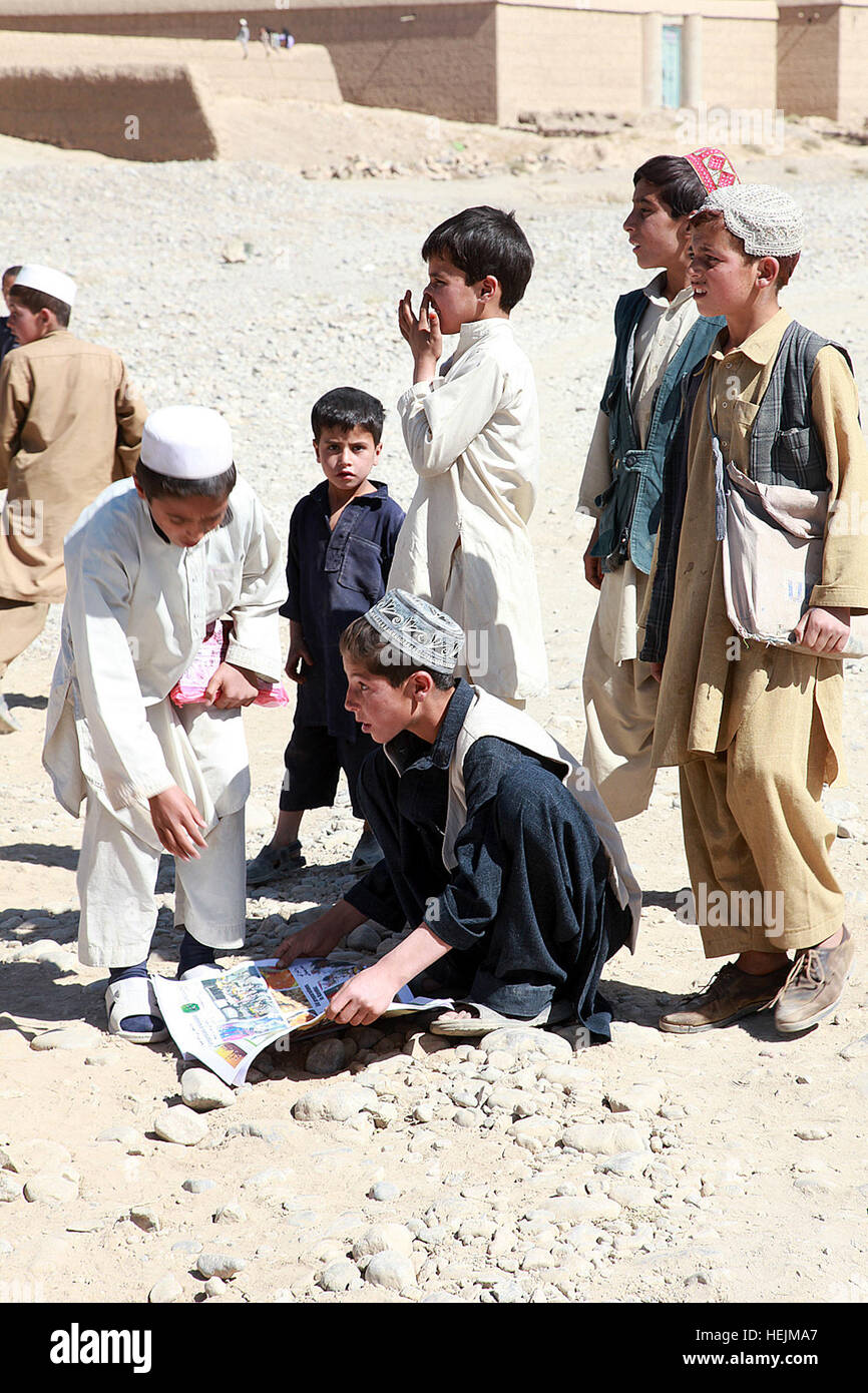 Afghan boys read the newspapers handed out by members of the 4th Candac ...