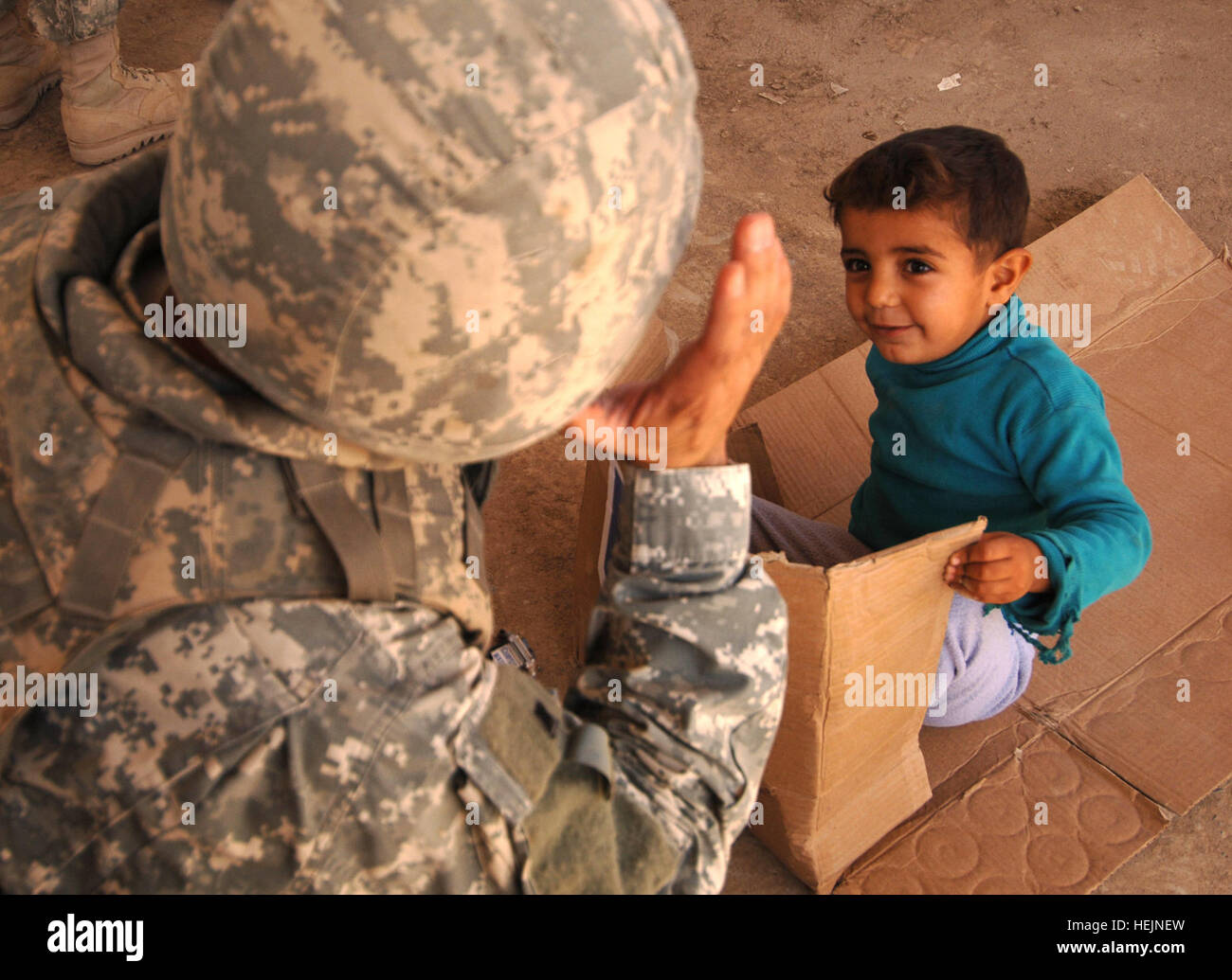 A young Iraqi boy smiles during a conversation with a U.S. Soldier ...