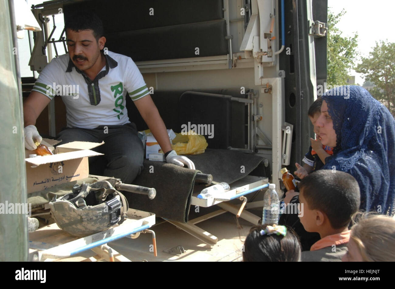 An Iraqi medic prepares to give some medicine to an Iraqi woman during ...