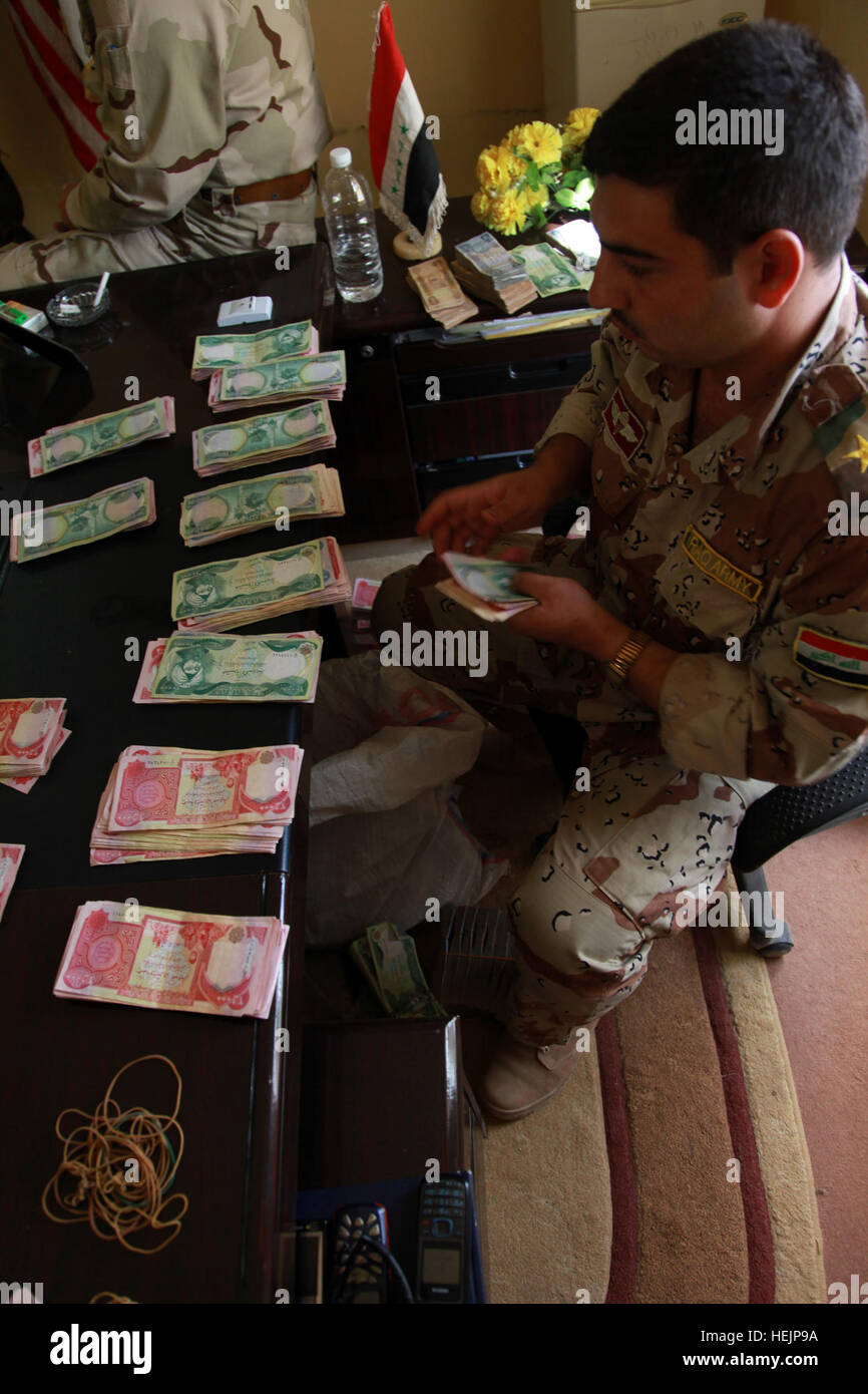 An Iraqi soldier assigned to the 47th Iraqi Army Brigade, counts out ...