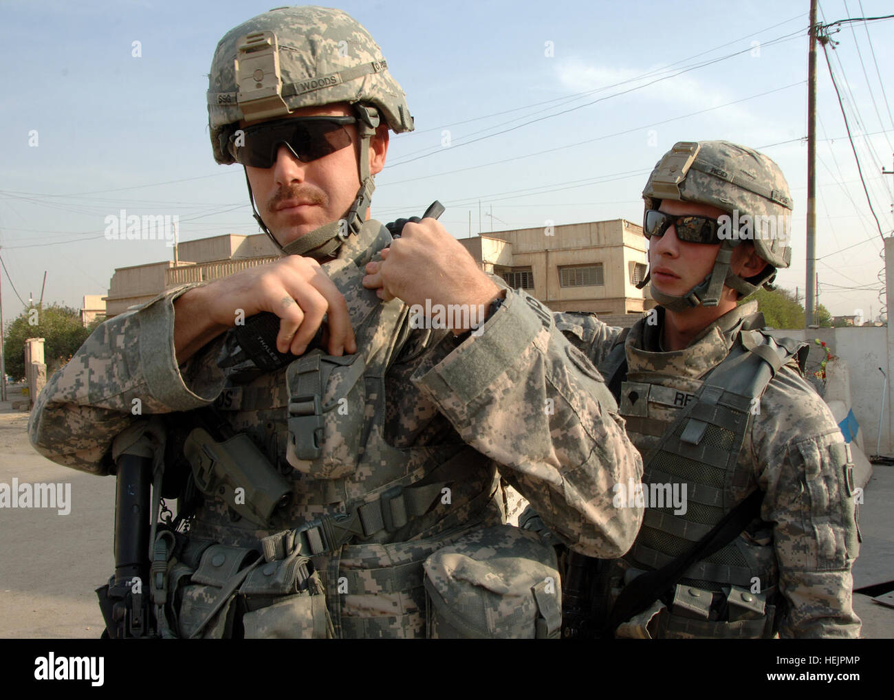 U.S. Army Spc. Robert Reid helps Staff Sgt. Nicholas Woods, both ...