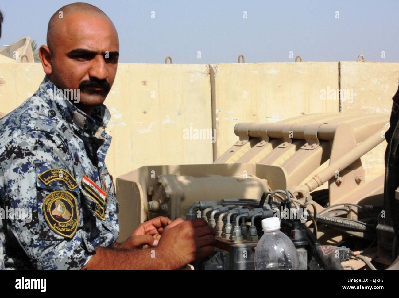 Carefully manipulating the controls to the arm of a Husky, Iraqi police ...