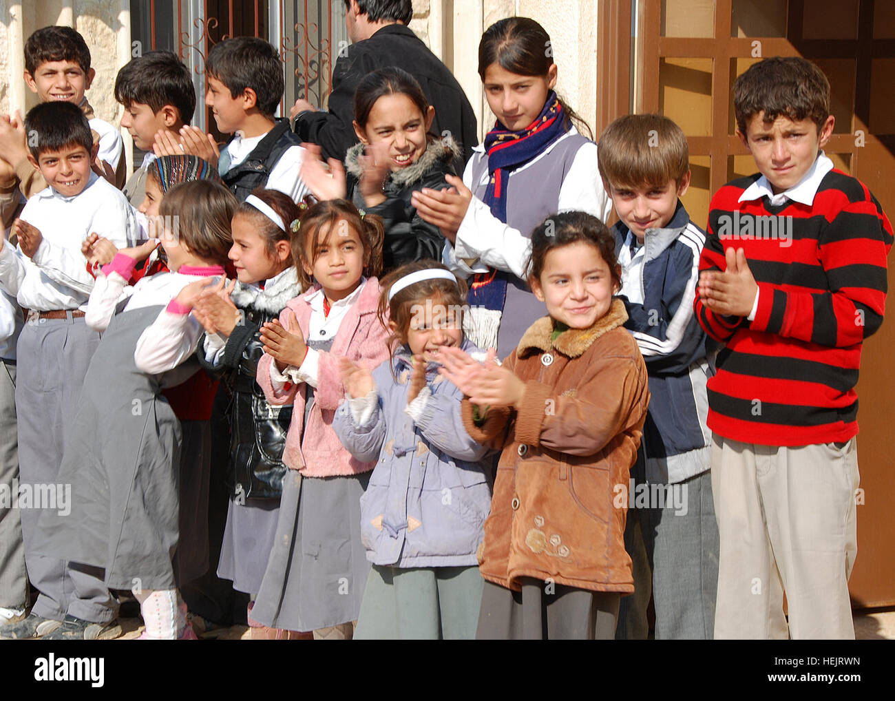 Children clap as the ribbon is cut at the opening of their new ...