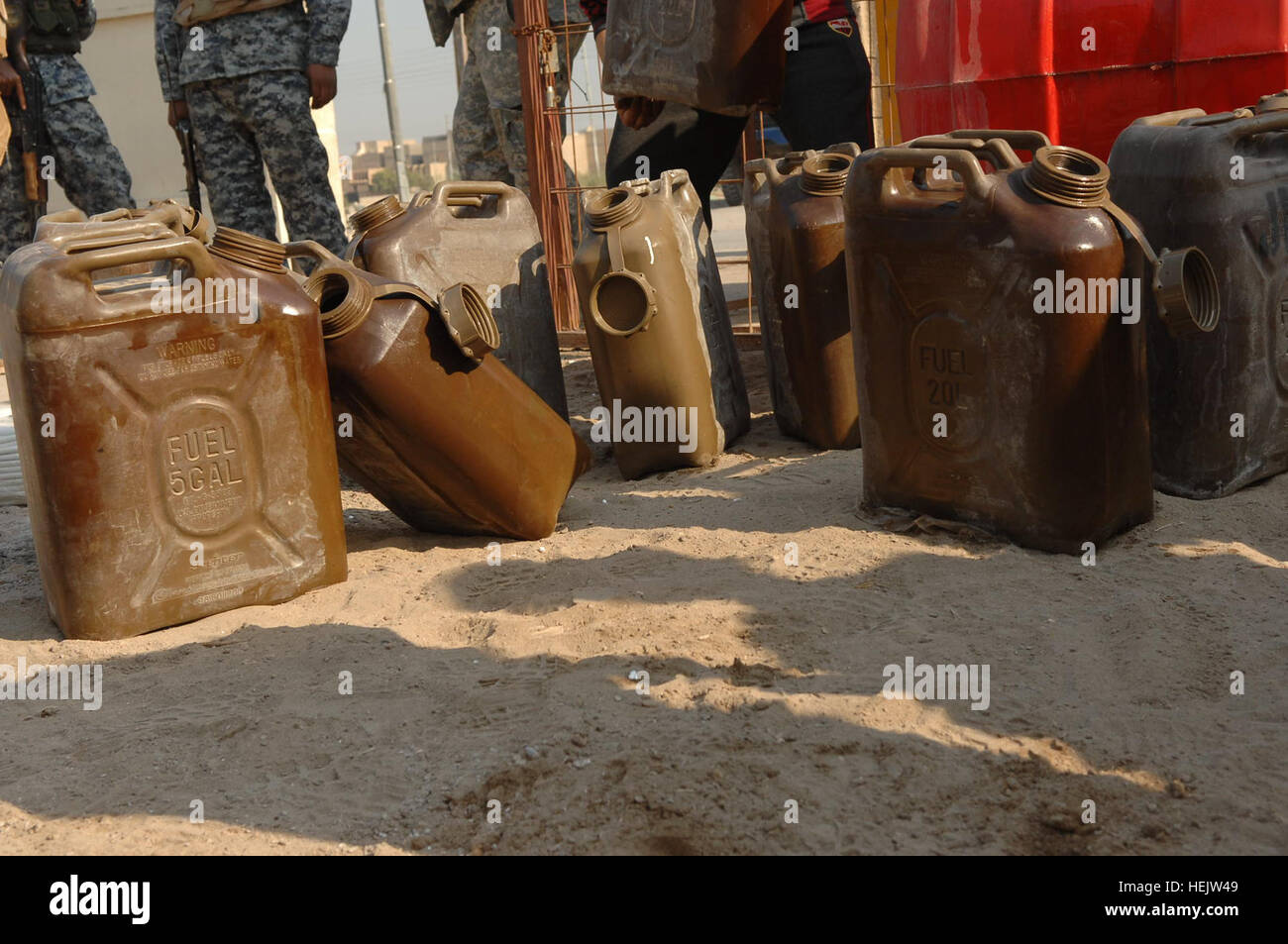 Empty fuel canisters are lined up on the ground after being emptied ...