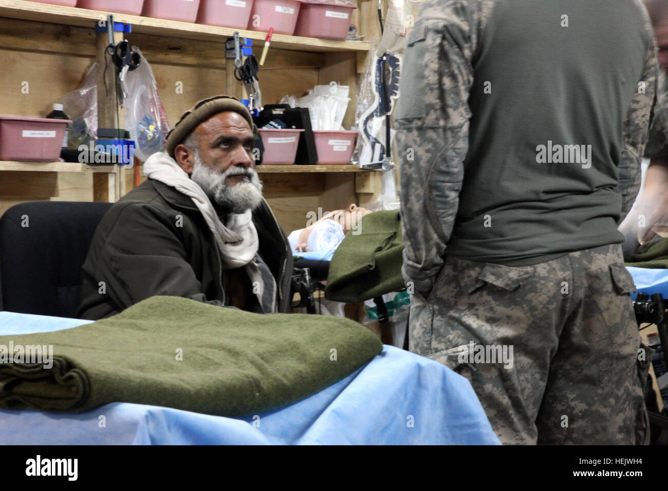 An Afghan boy's father listens to the translator explaining the process ...