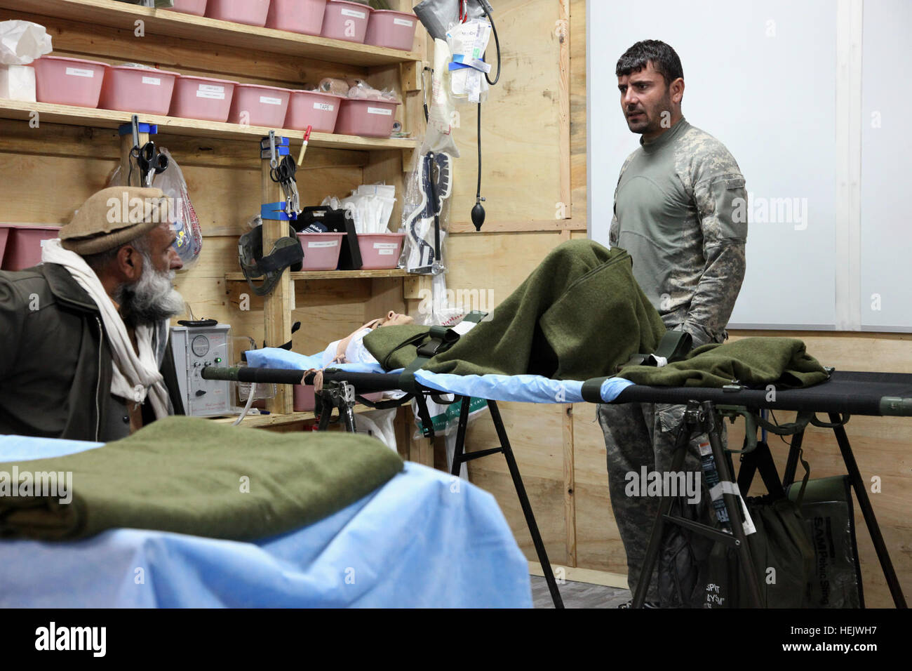 An Afghan boy's father listens to the translator explaining the process ...
