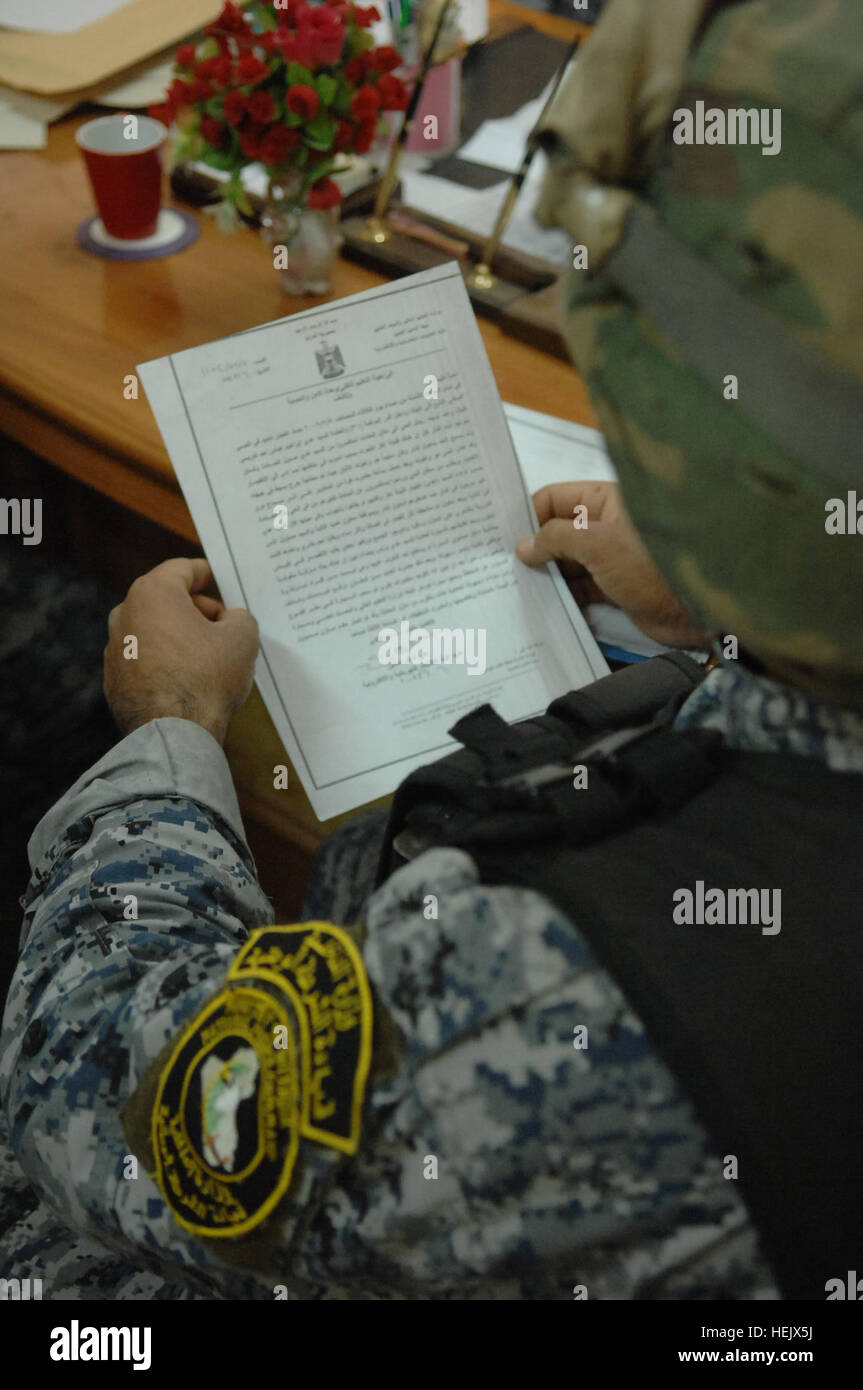 An Iraqi Federal Policeman searches through documents during a joint ...