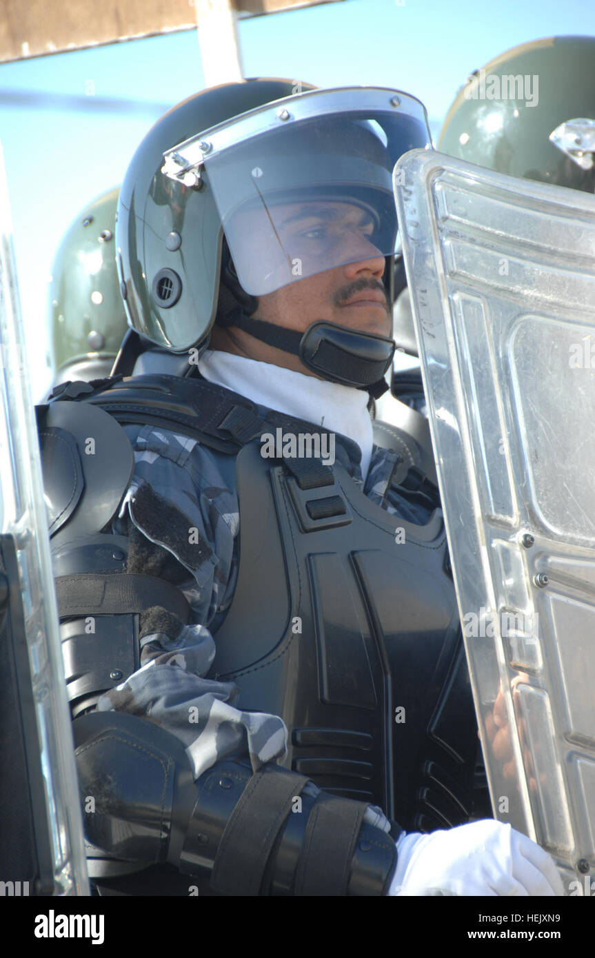An Iraqi Riot Control officer rides in the back of a pick-up truck ...