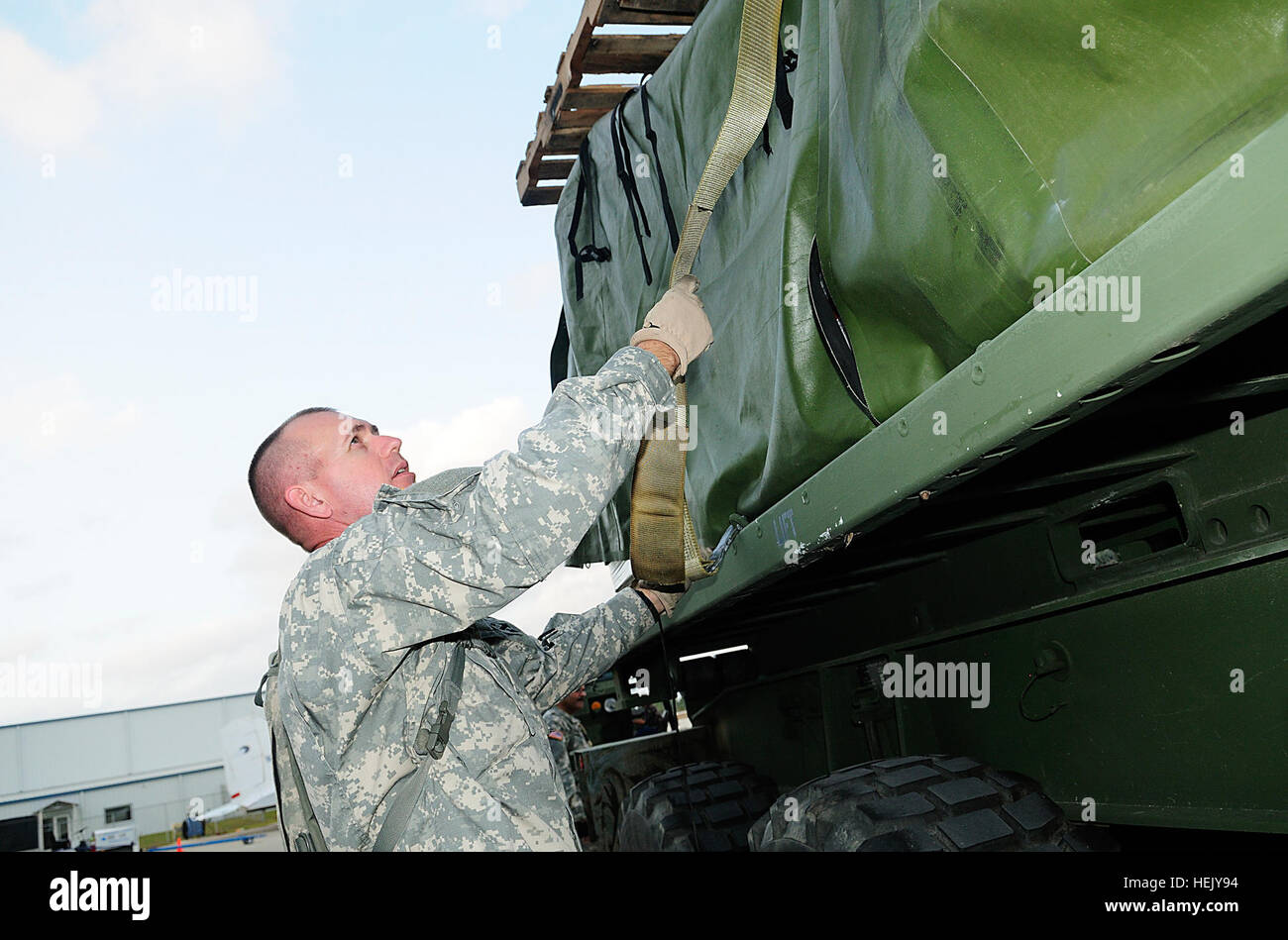 Army Reserve Sgt. Clarence Knight fastens a cargo strap on a Palletized ...