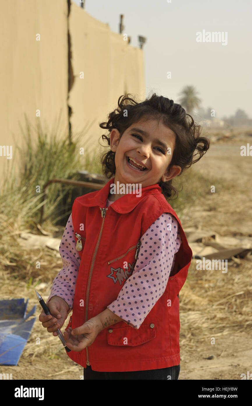 A young Iraqi girl shares a smile with U.S. Airmen from the 447th Air ...
