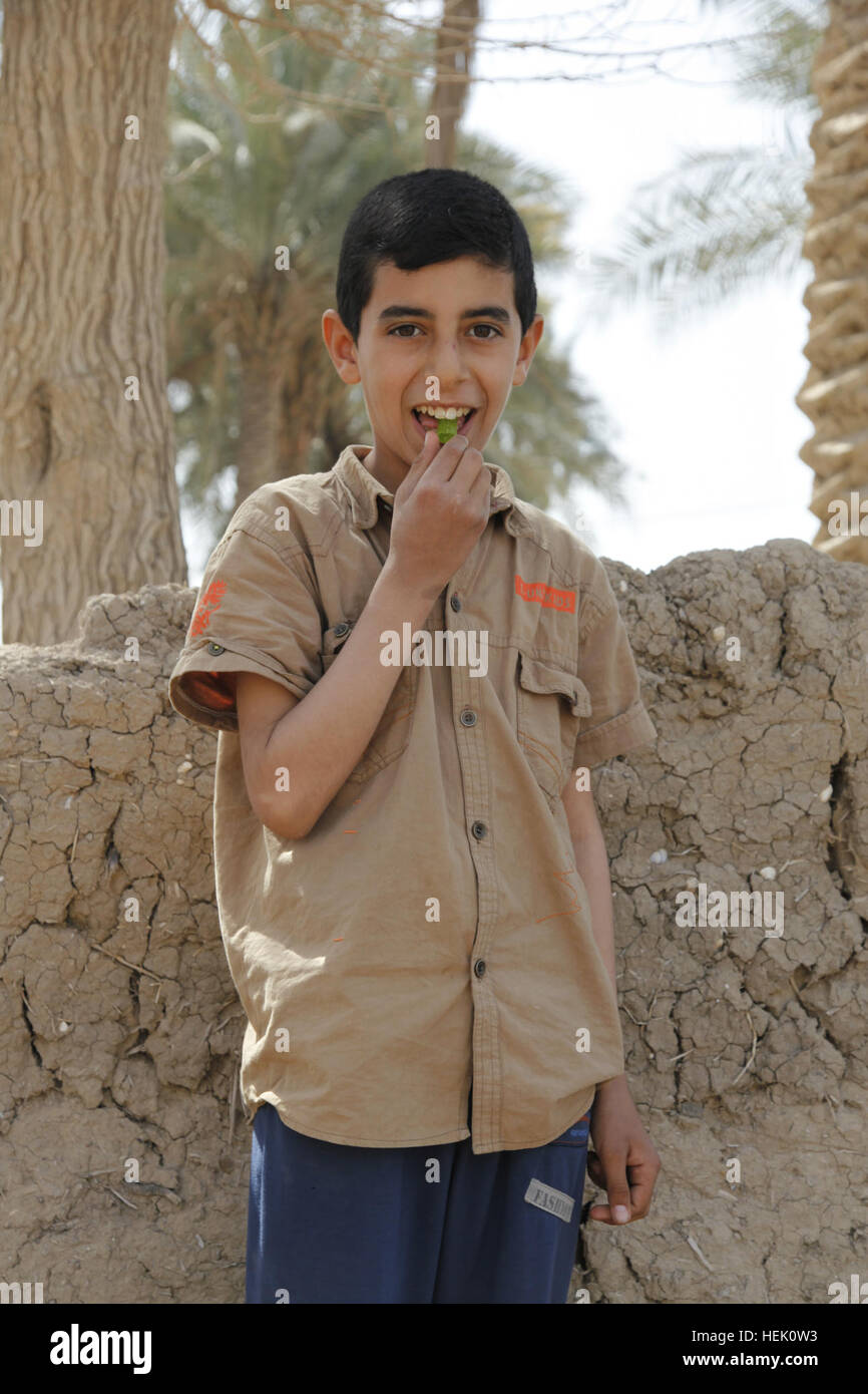 An Iraqi boy puts a piece of candy he just received from a U.S. Soldier ...