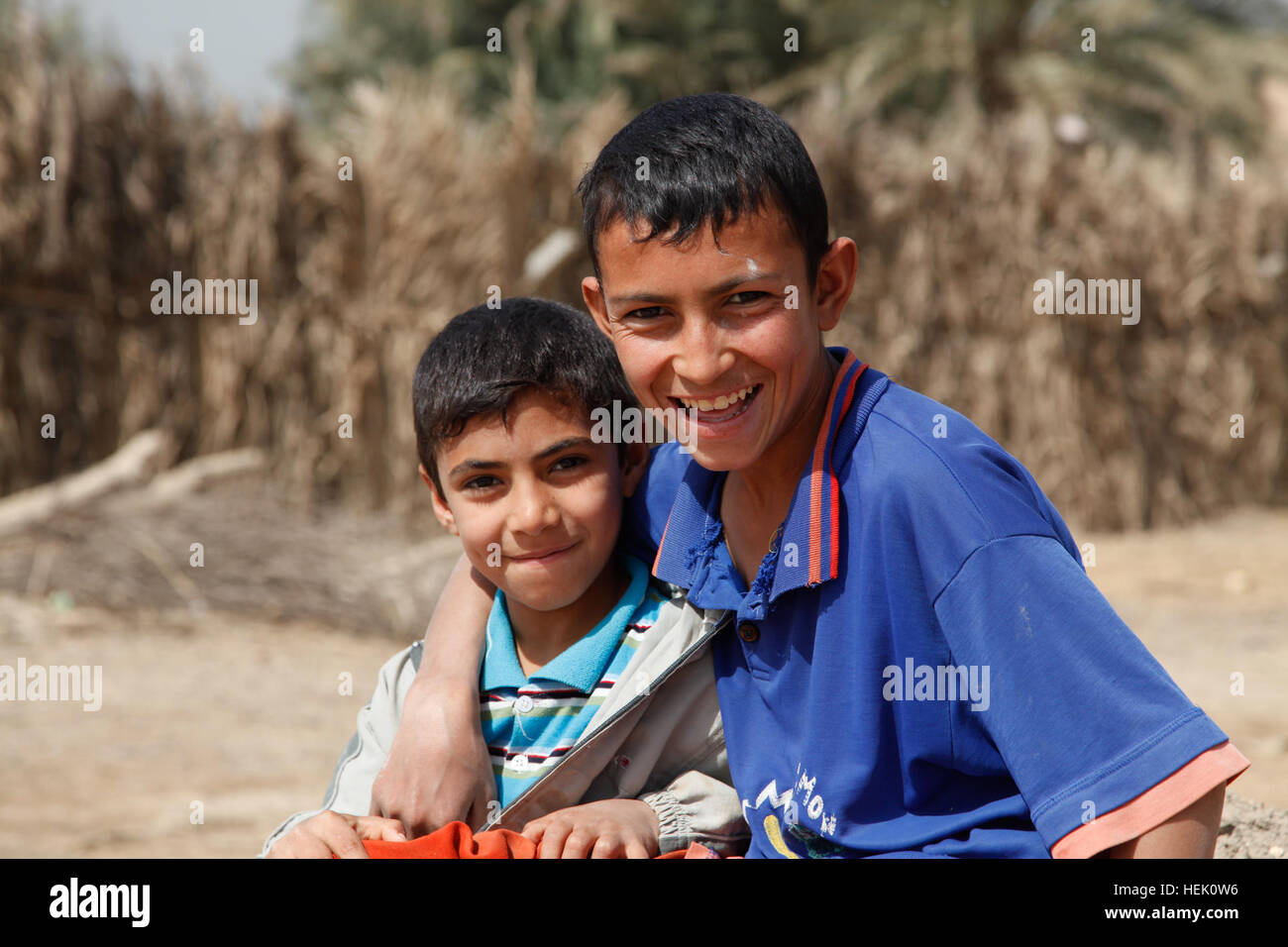 Two local Iraqi boys sit and smile while U.S. Soldiers in the area ...