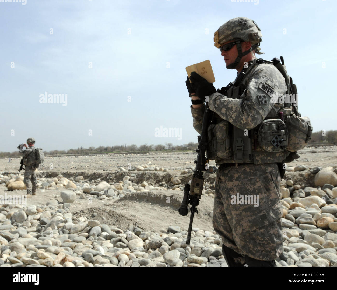 U.S. Army military police personnel monitor construction of a retaining ...
