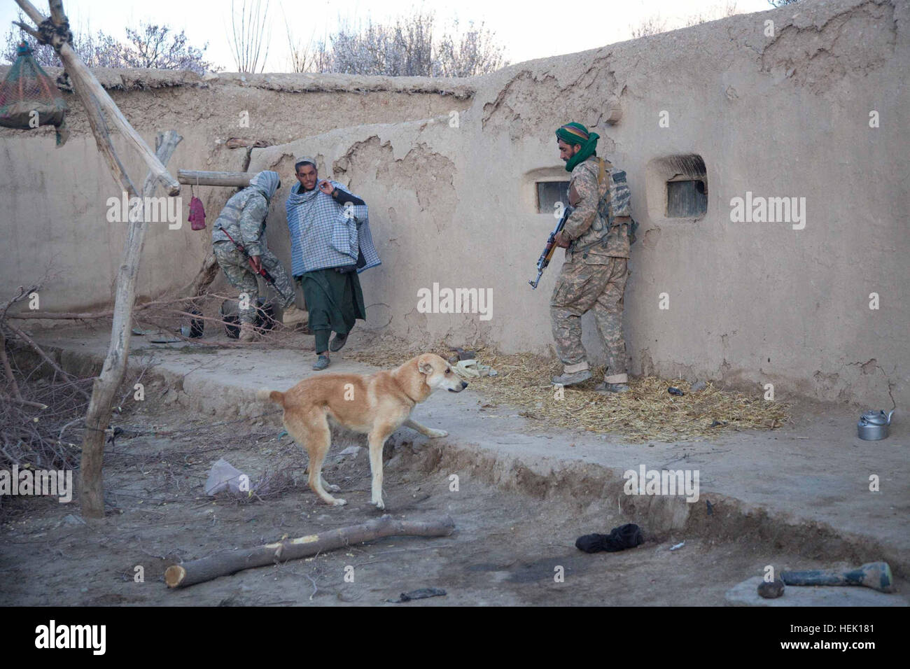 An Afghan policeman searches a compound in Oruzgan, Afghanistan on ...