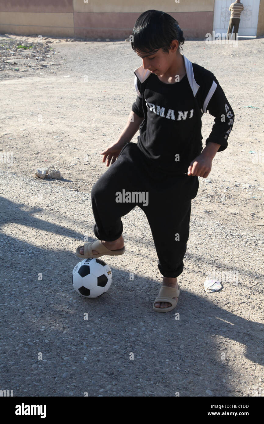 An Iraqi child plays with a soccer ball given out by U.S. Army soldiers ...