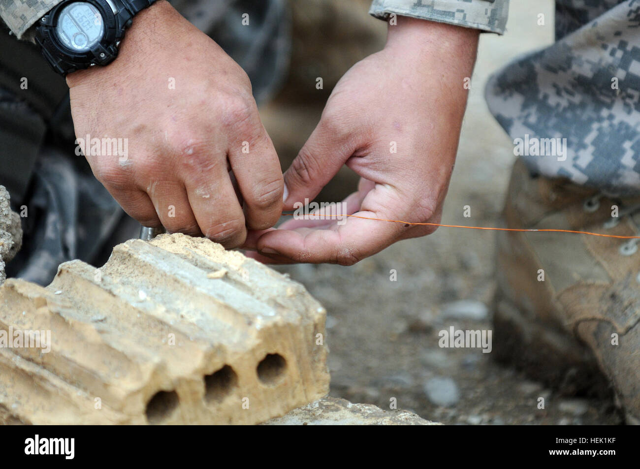 A Soldier reconnects a simulated tripwire after learning how it works ...
