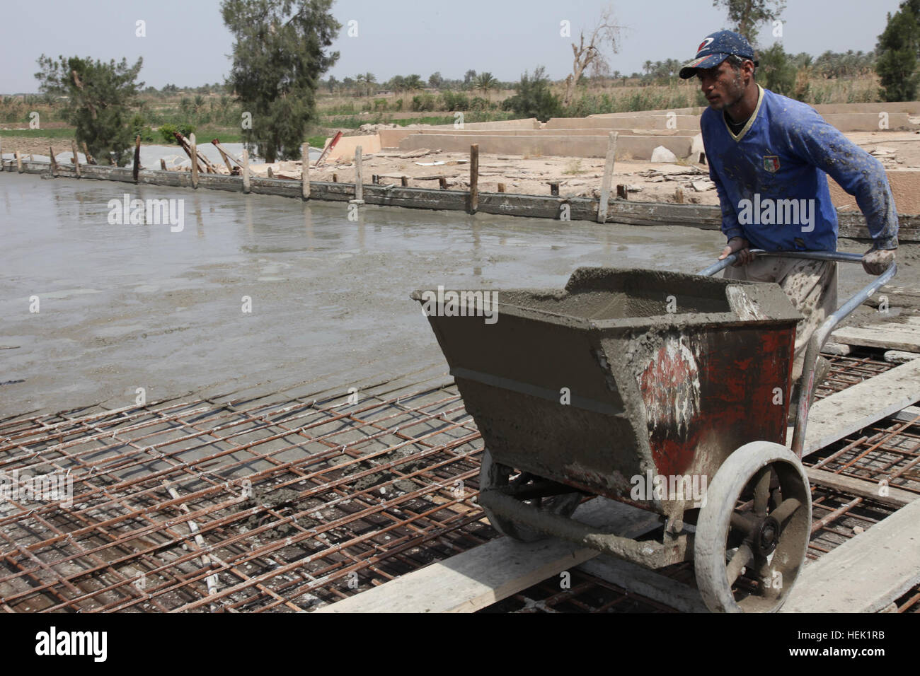 An Iraqi man pushes a cart filled with cement on the roof of the new ...