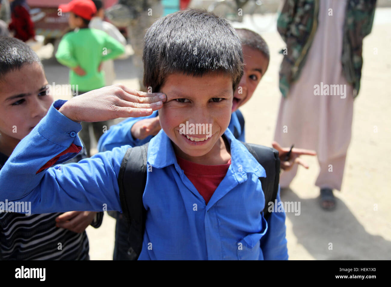 An Afghan child gives a salute as he poses for a picture in a local ...