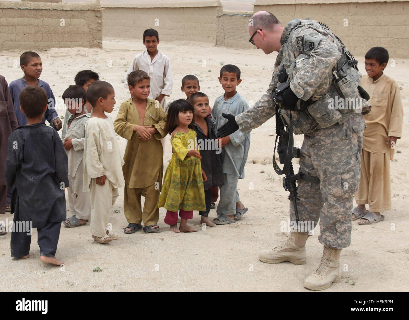 U.S. Army Maj. Allan Gillman greets an Afghan girl with a hand shake ...