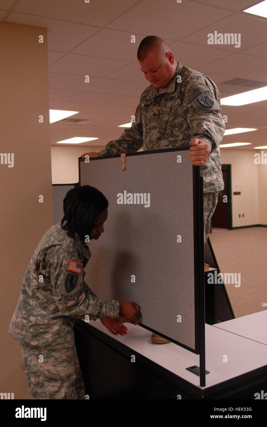 Sgt. Kelli Stovell aligns the placement of a cubicle wall while Sgt ...
