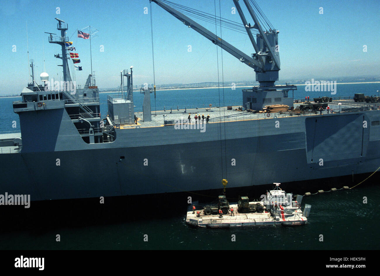 Cranes aboard the vehicle cargo ship USNS ALTAIR (T-AKR 291) lower ...