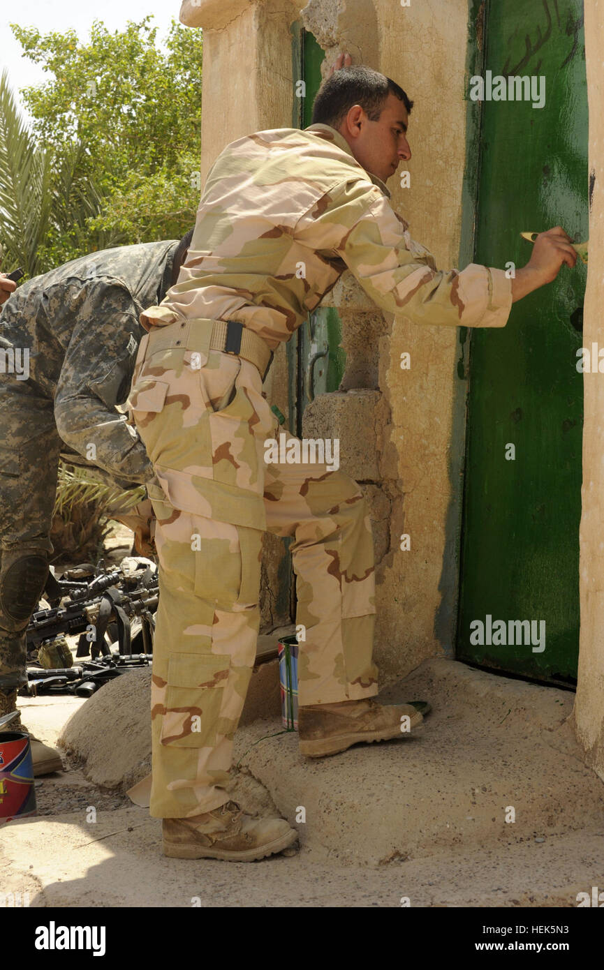 Iraqi Army soldier paints school walls in Diyala province, Iraq, Sept ...