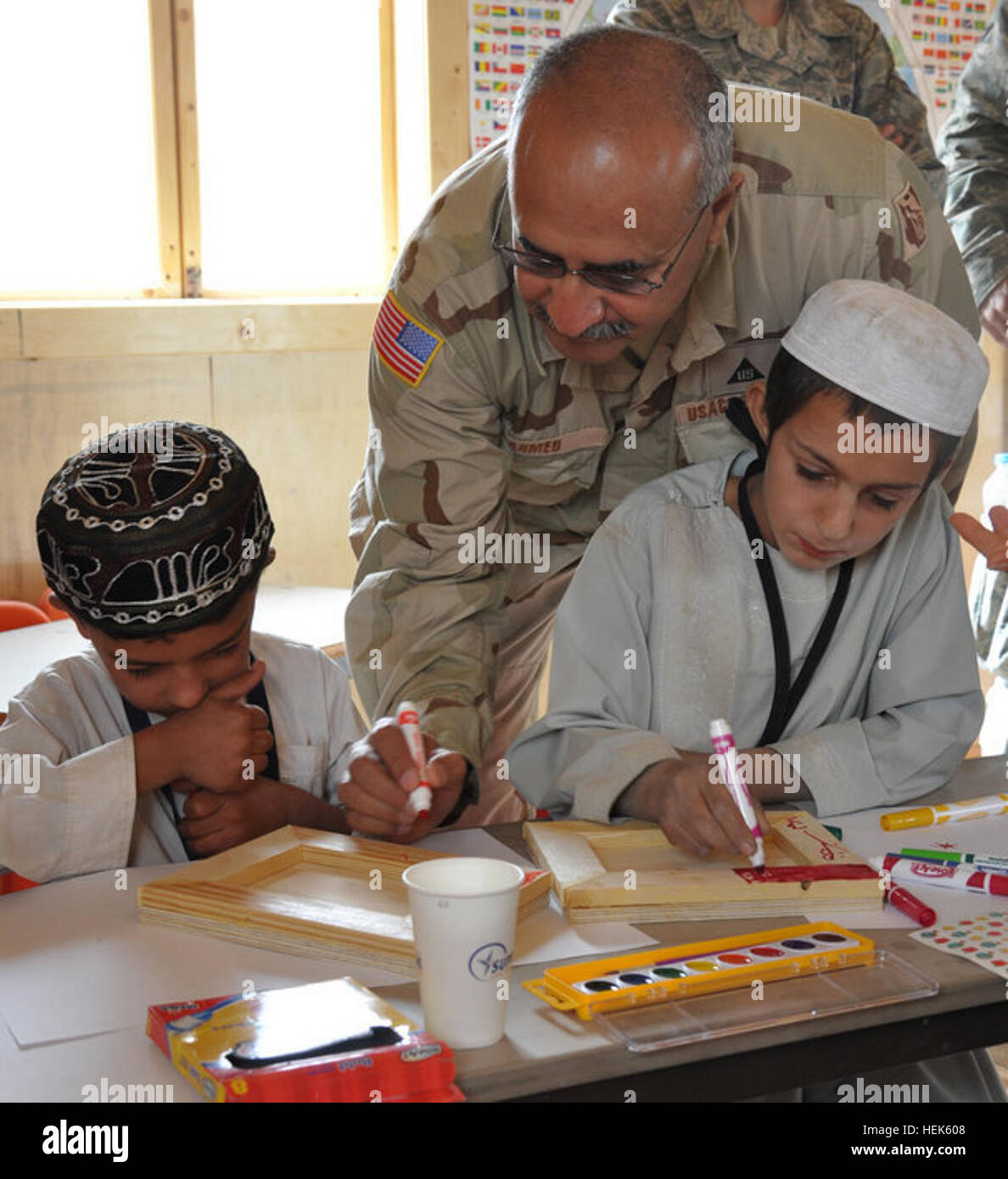 Javed Ahmed, highway engineer with the 579th Engineer Detachment, helps ...