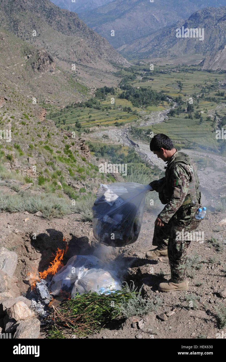 An Afghan National Army Soldier burns trash at a mountaintop ...