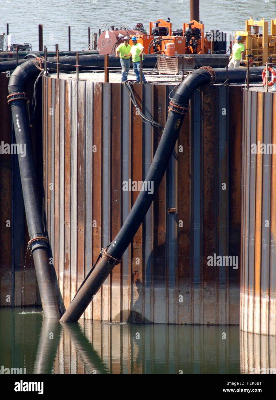 Work crews from C.J. Mahan pump water out of the coffer dam being ...